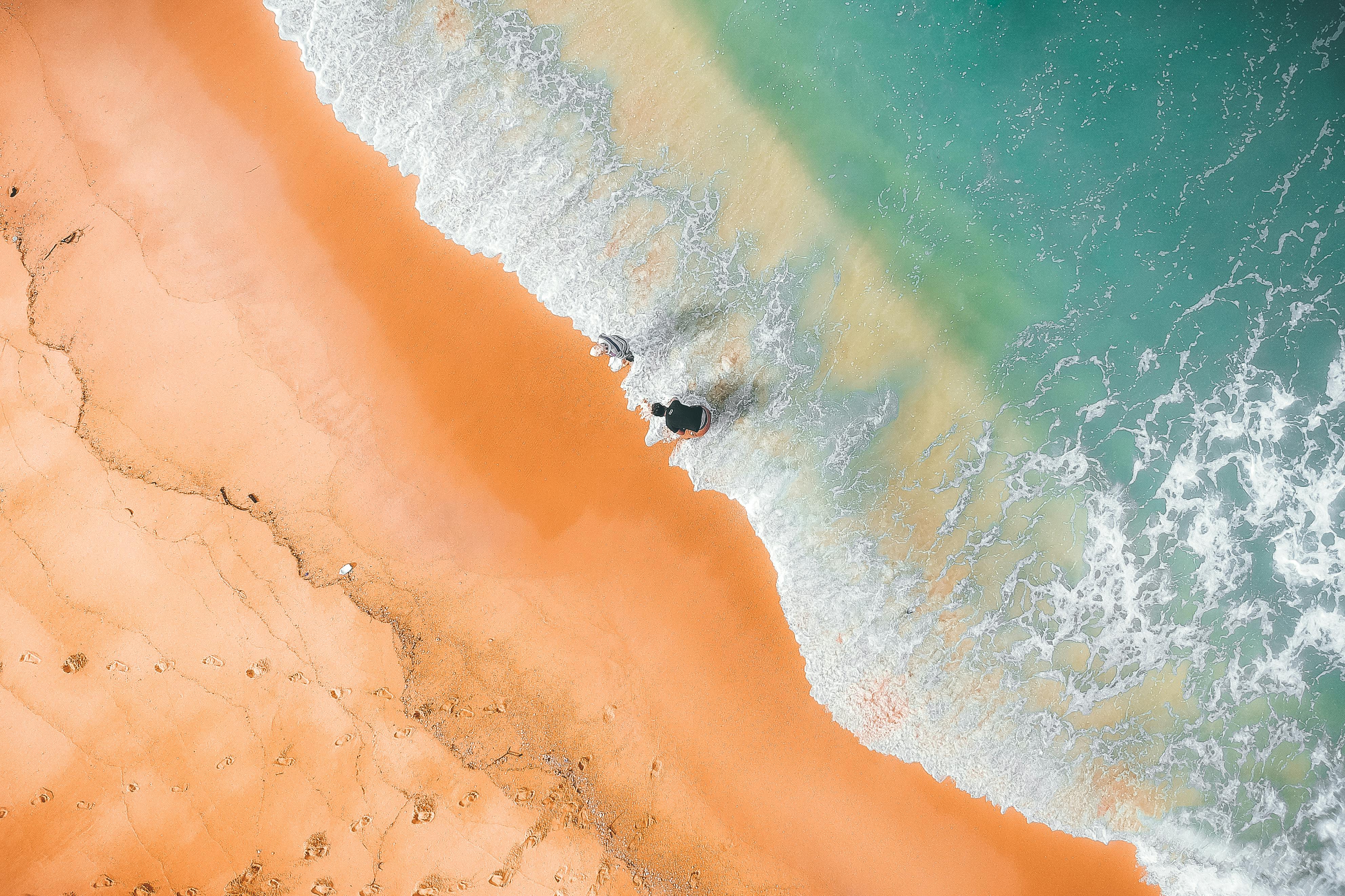 Transparent sea water on bright sandy beach in daylight · Free Stock Photo