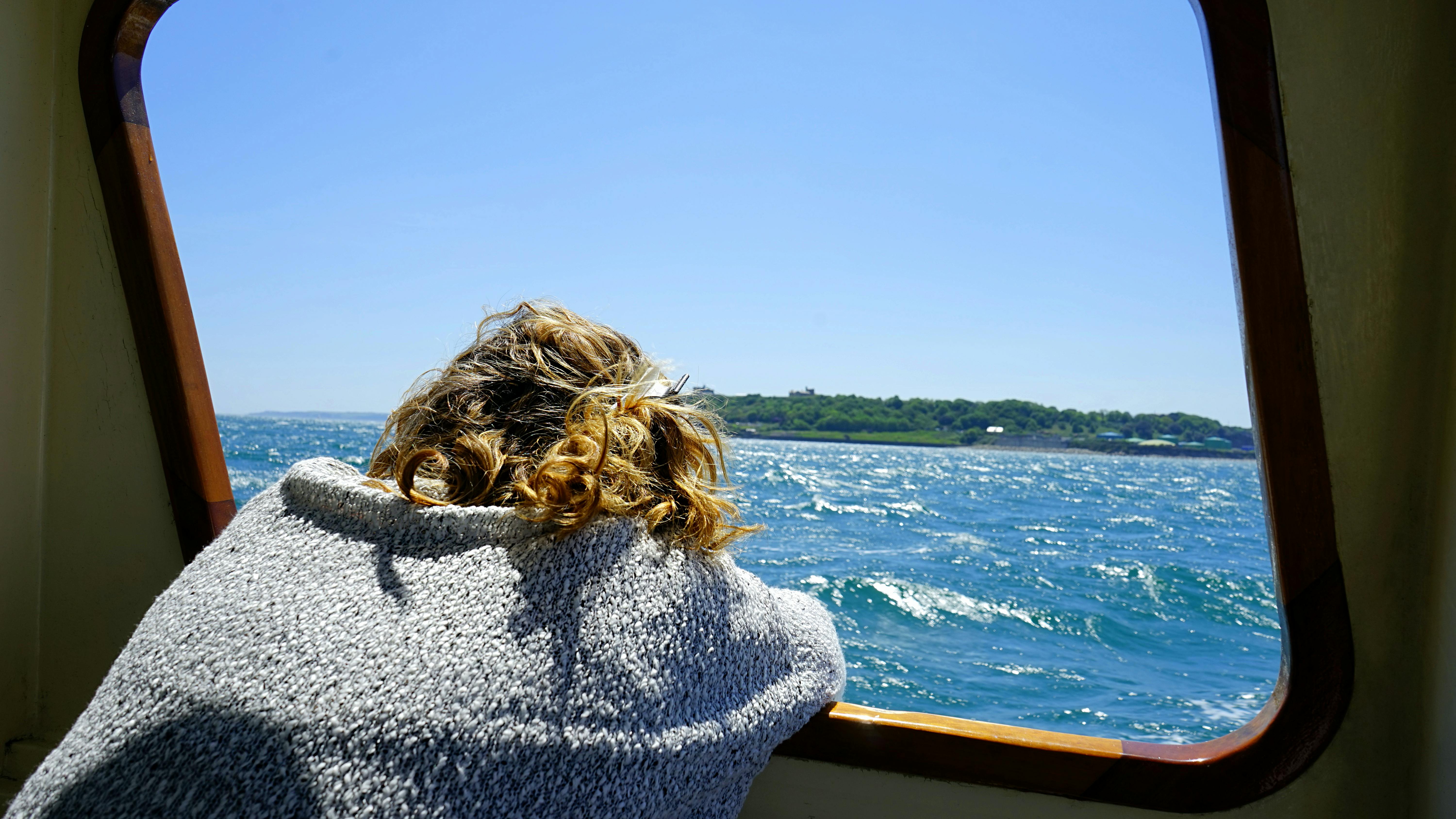 Woman in Blue Sweater Peaking Out The Window · Free Stock Photo