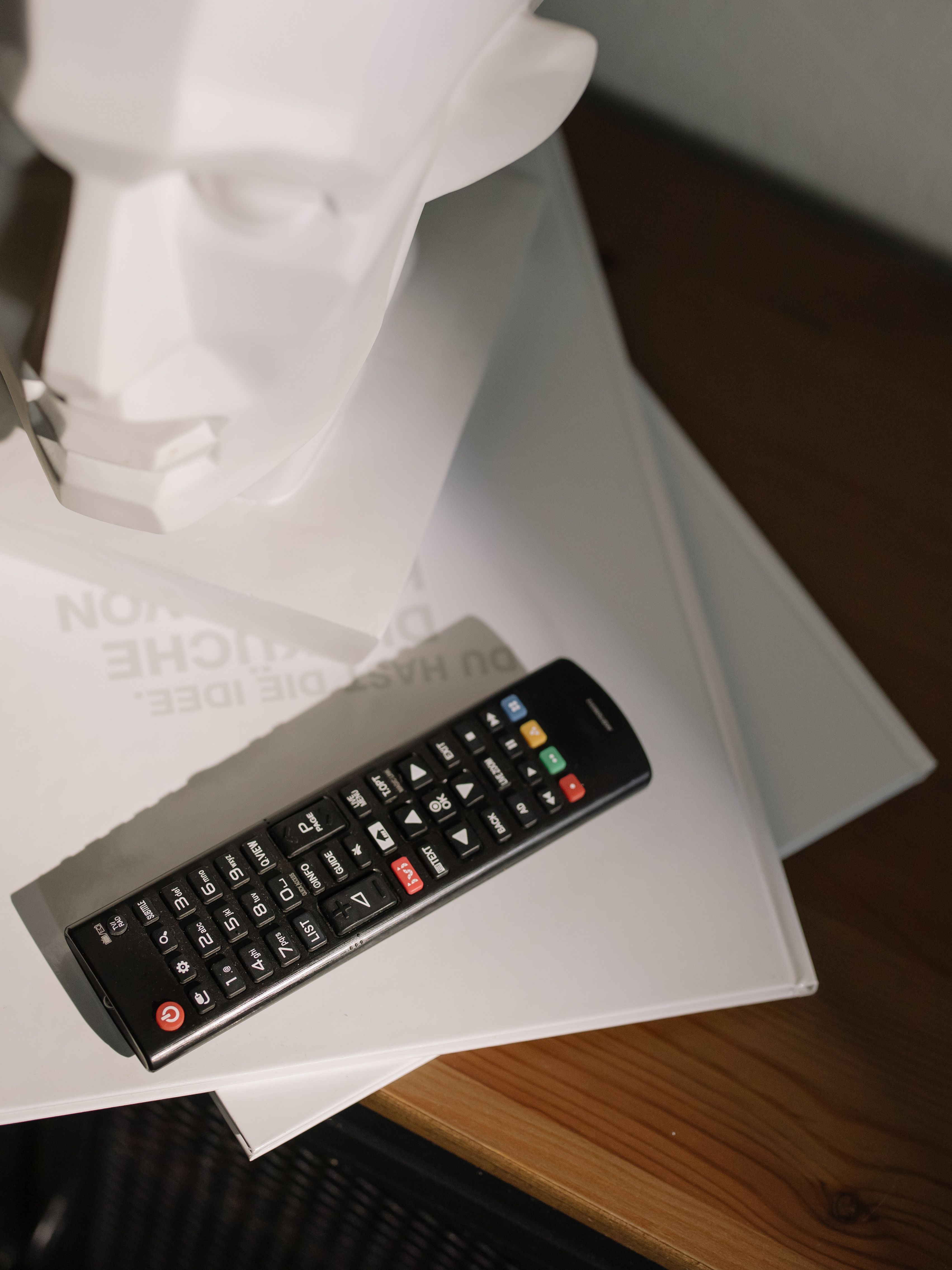 Black Remote Control Placed on a White Paper · Free Stock Photo