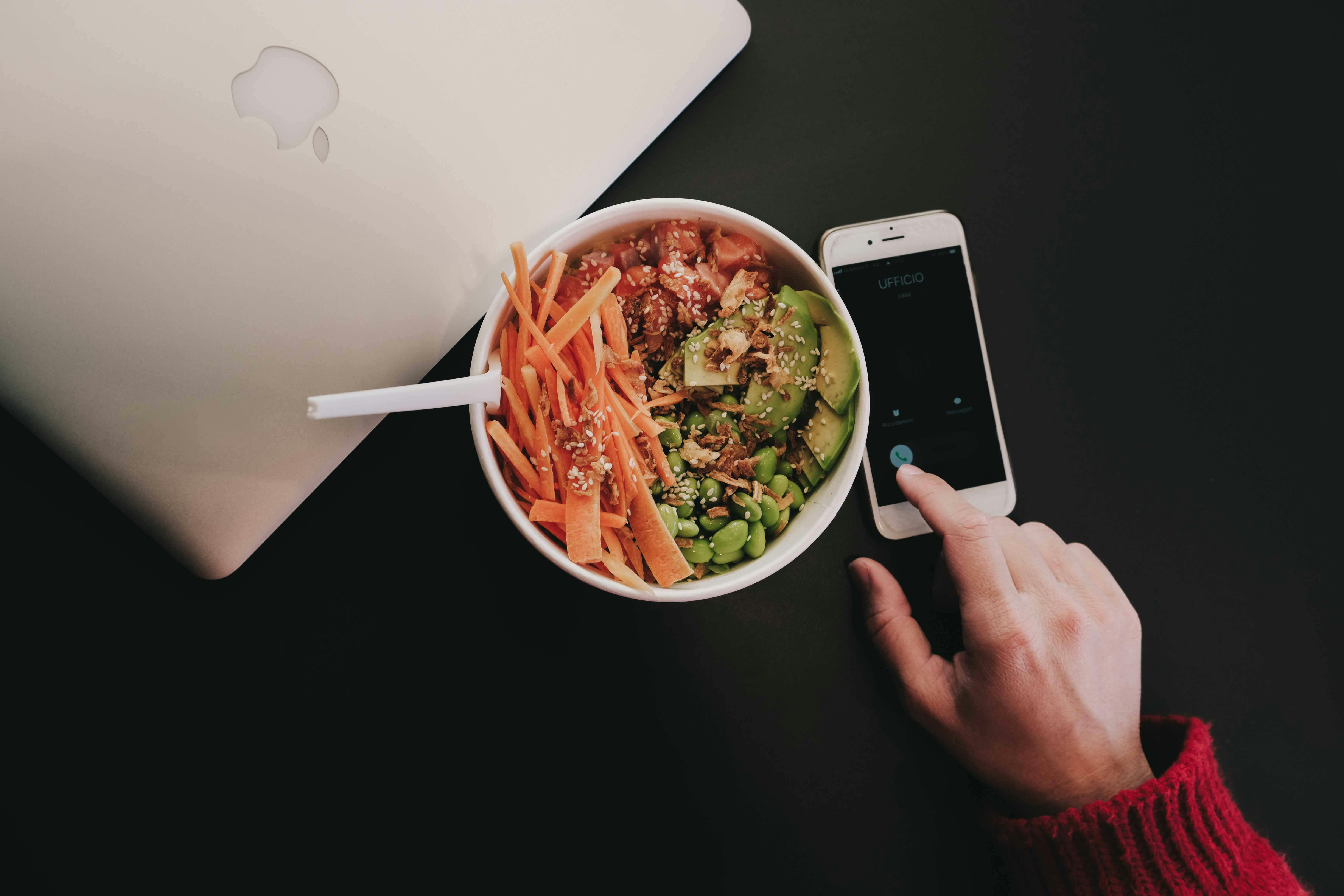 Woman Holding Iphone While Eating · Free Stock Photo