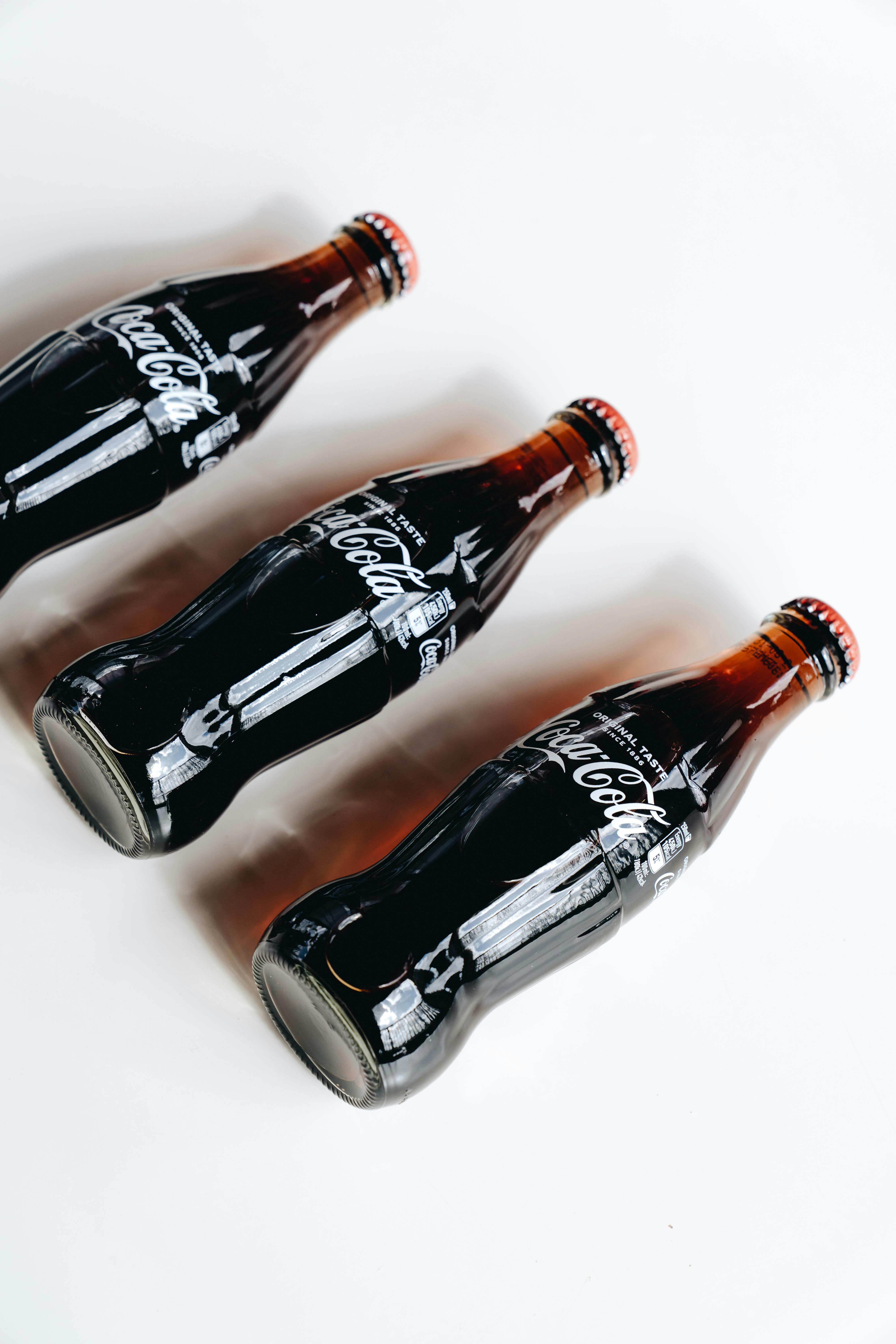 Three White and Brass Coca-cola Bottles · Free Stock Photo