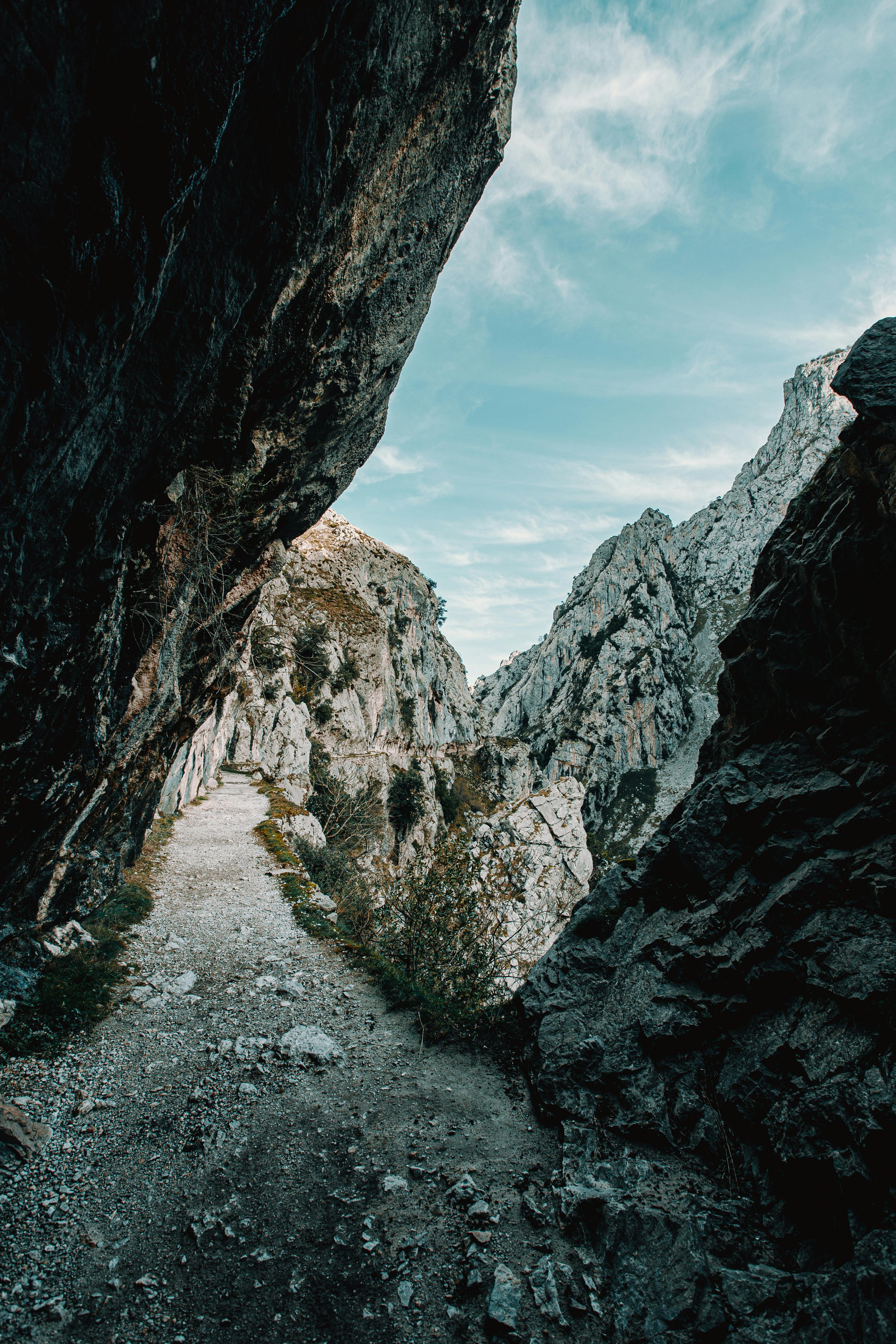 Empty footpath between cliff and rocks · Free Stock Photo