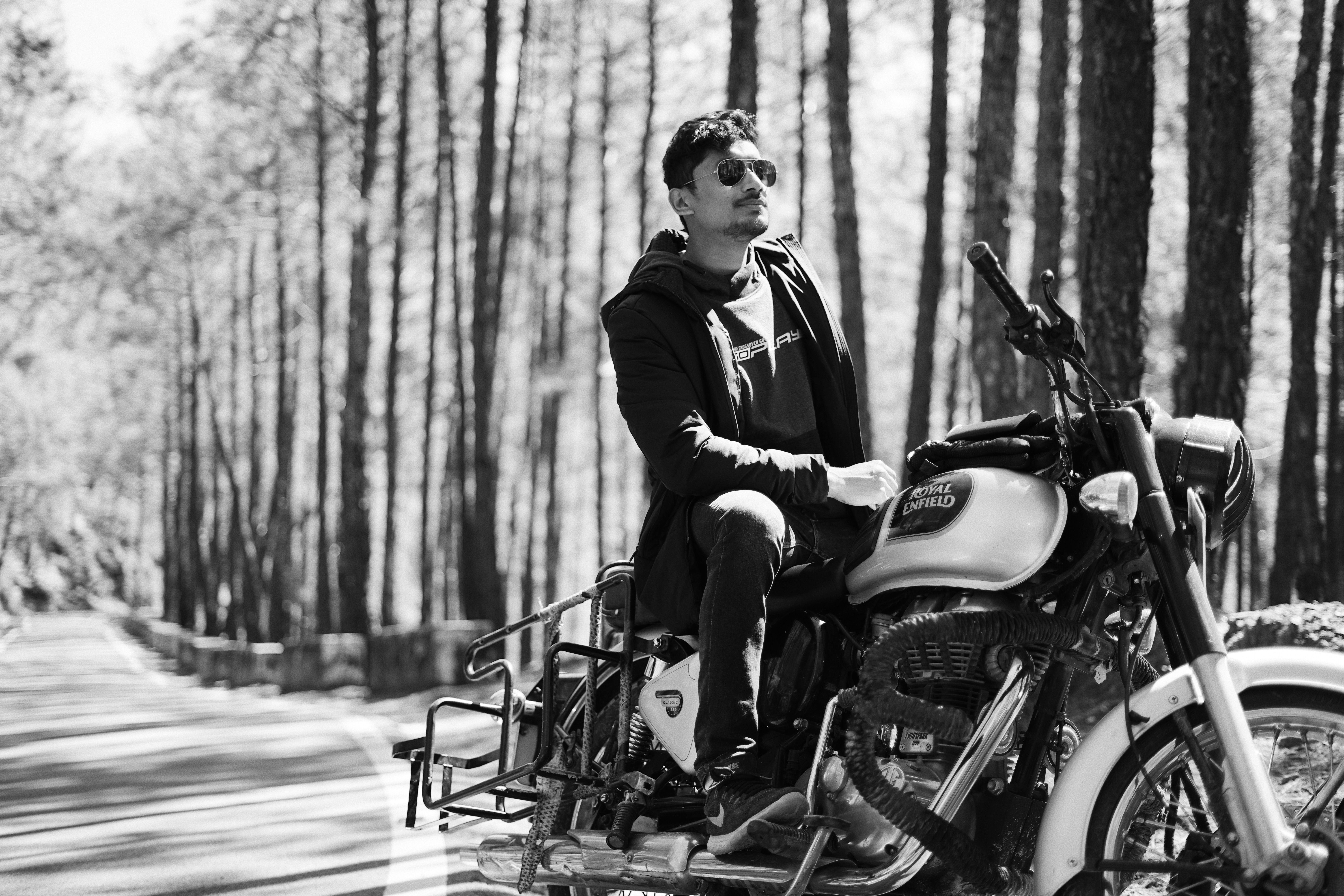 Brutal biker riding motorcycle in woods · Free Stock Photo