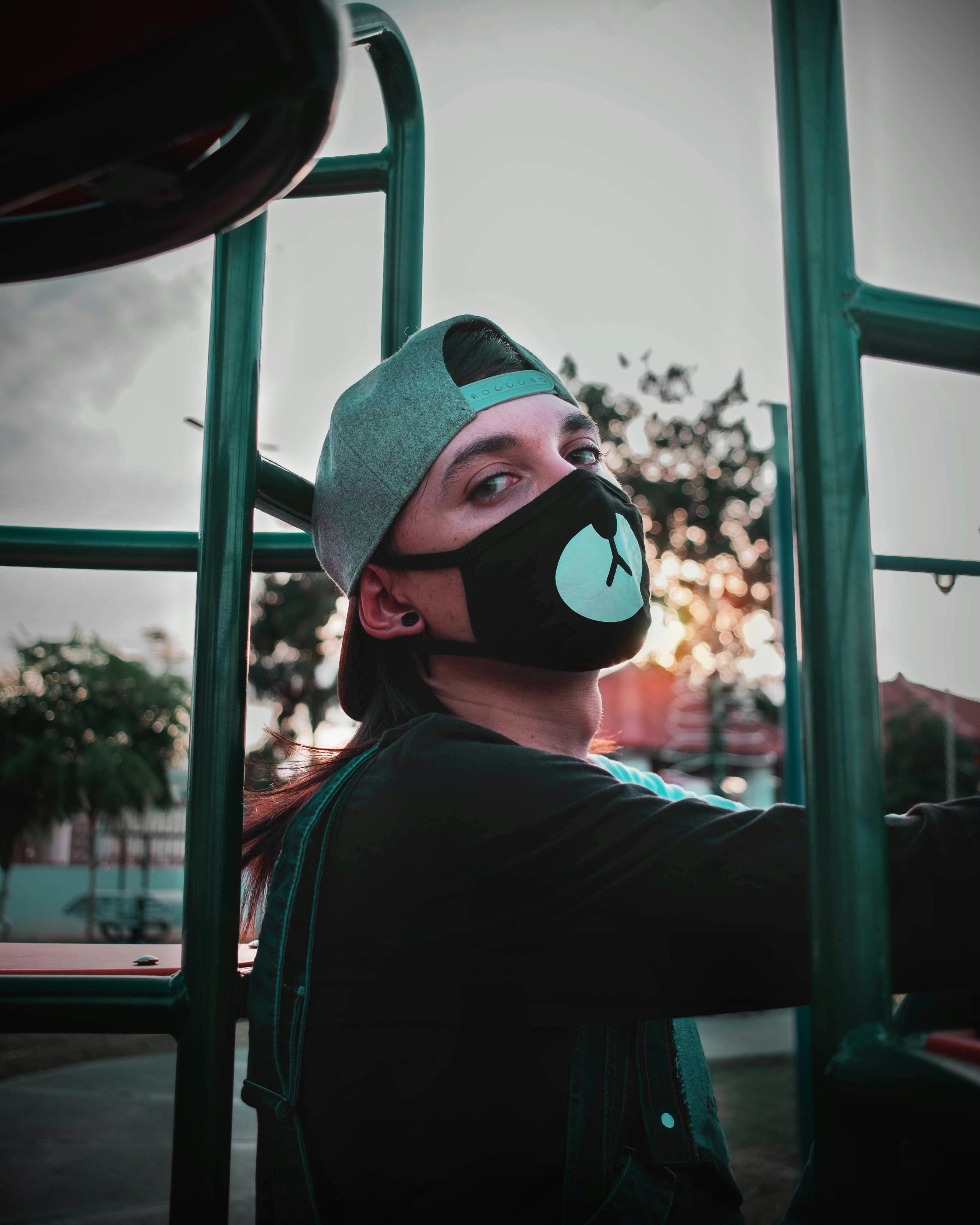 Youngster in cap and mask looking at camera · Free Stock Photo