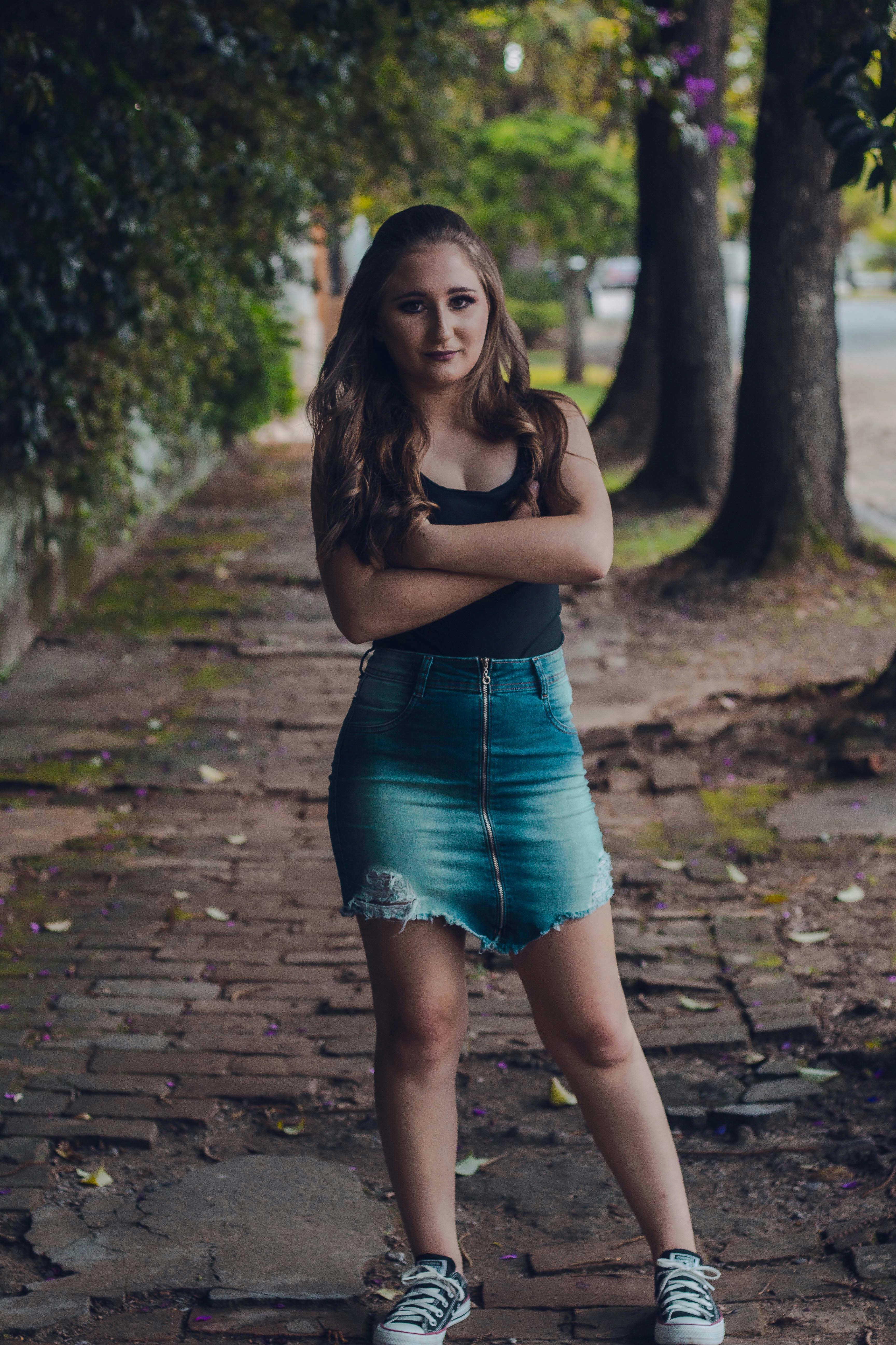 Attentive young Asian woman strolling along path in tropical greenhouse ...