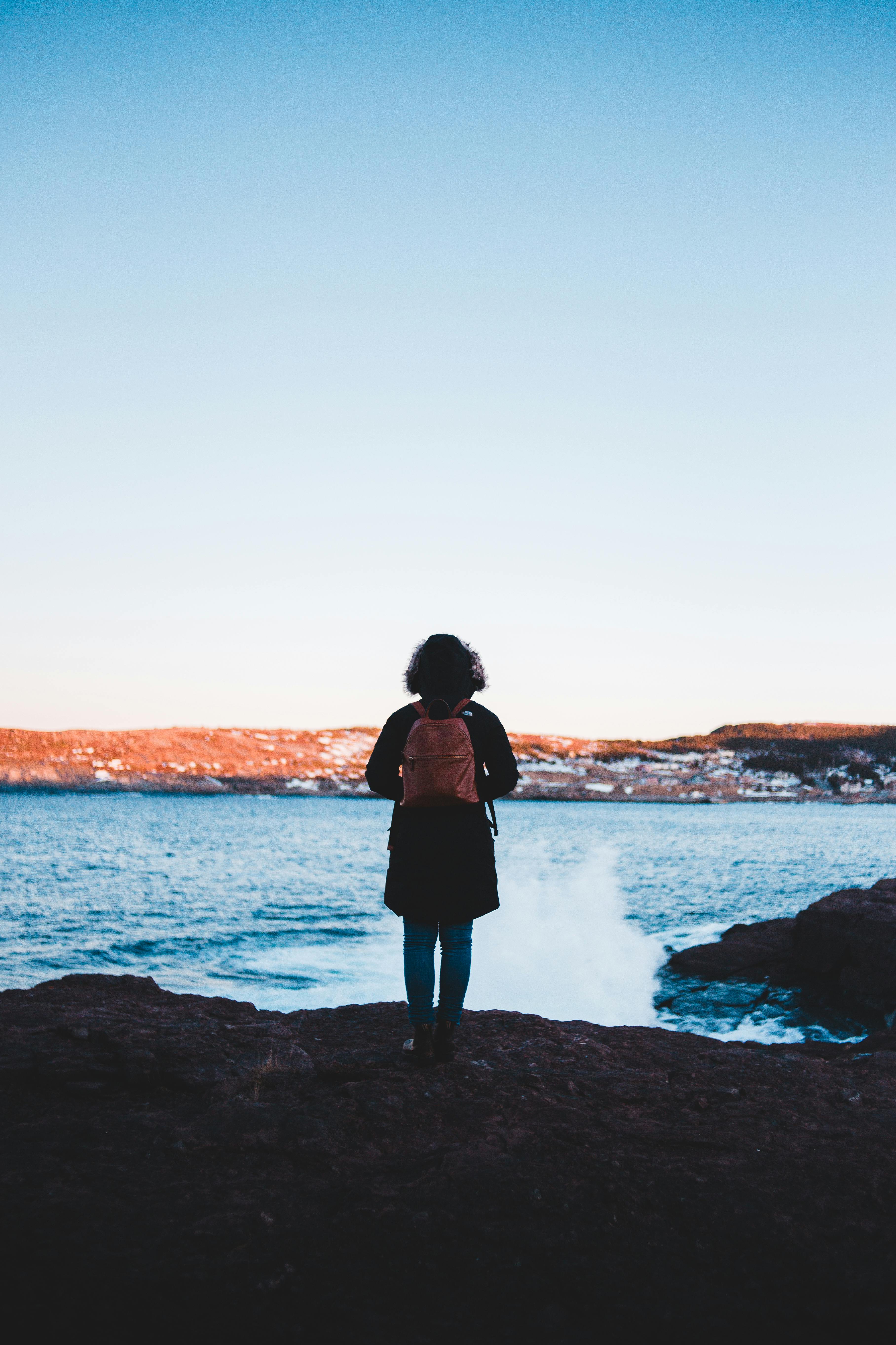 Photo Of Person Standing On Sea Shore · Free Stock Photo