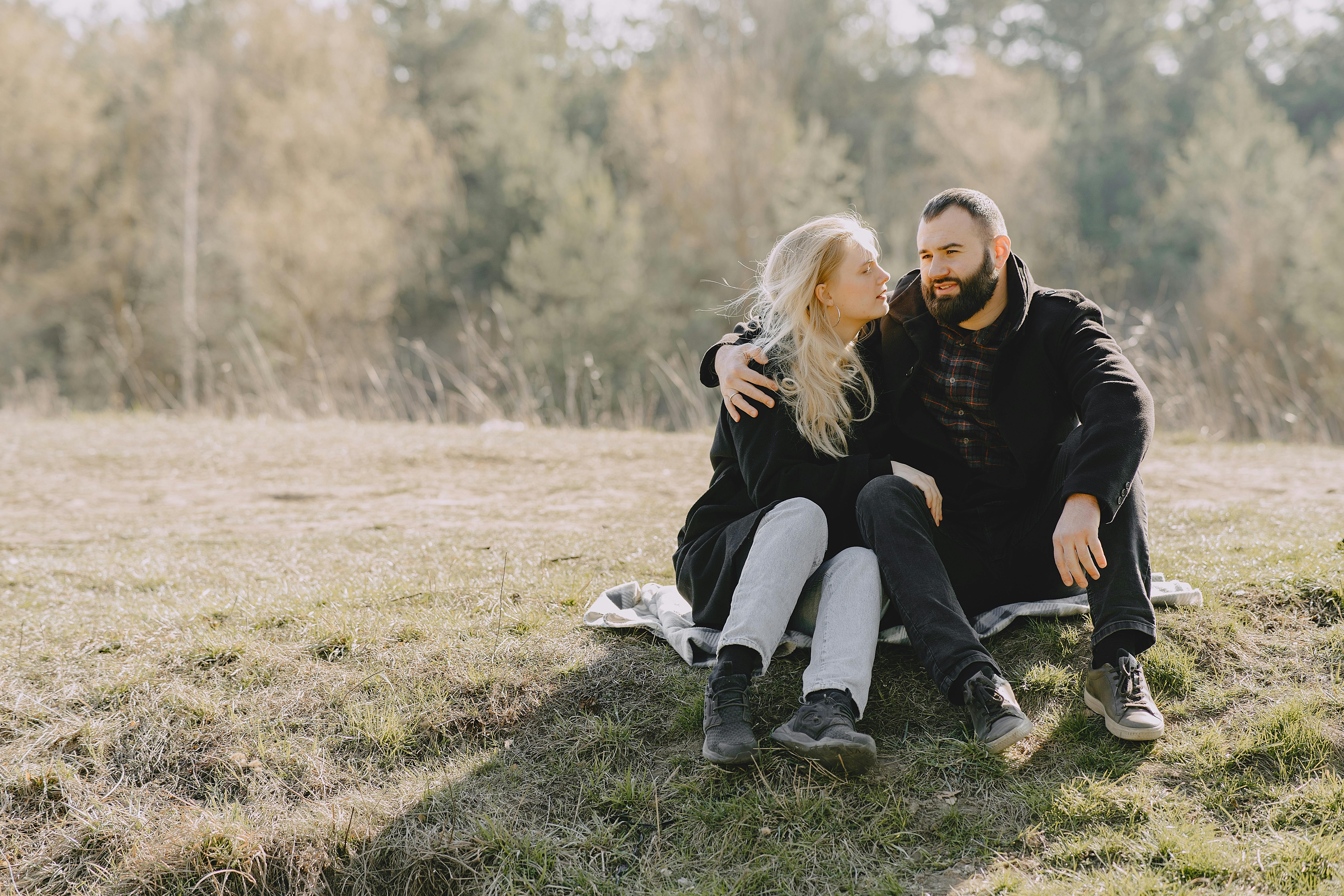 Thoughtful hugging couple resting on meadow · Free Stock Photo
