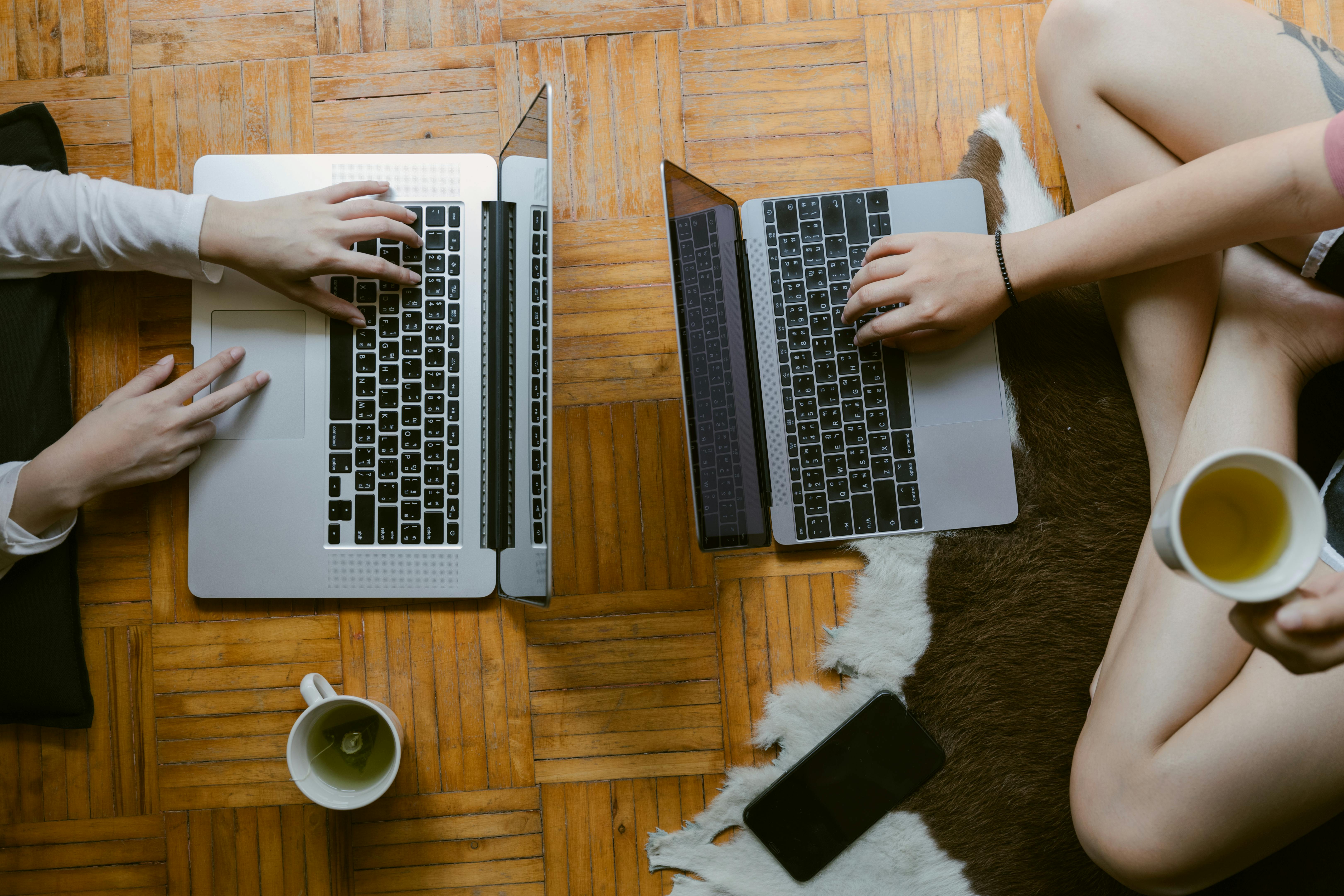 Crop women working remotely on laptops in living room · Free Stock Photo