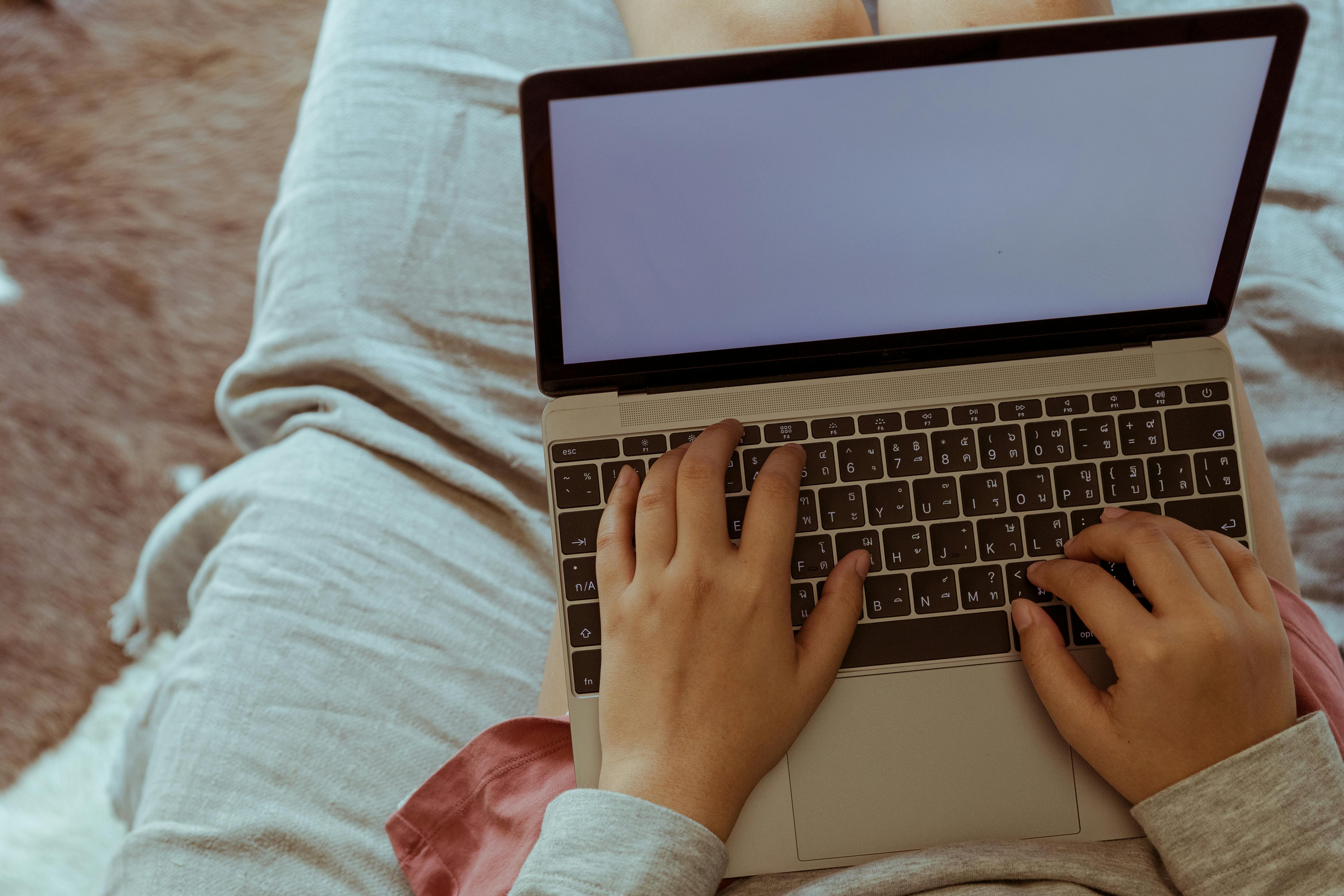Crop anonymous female freelancer typing on laptop with blank screen ...