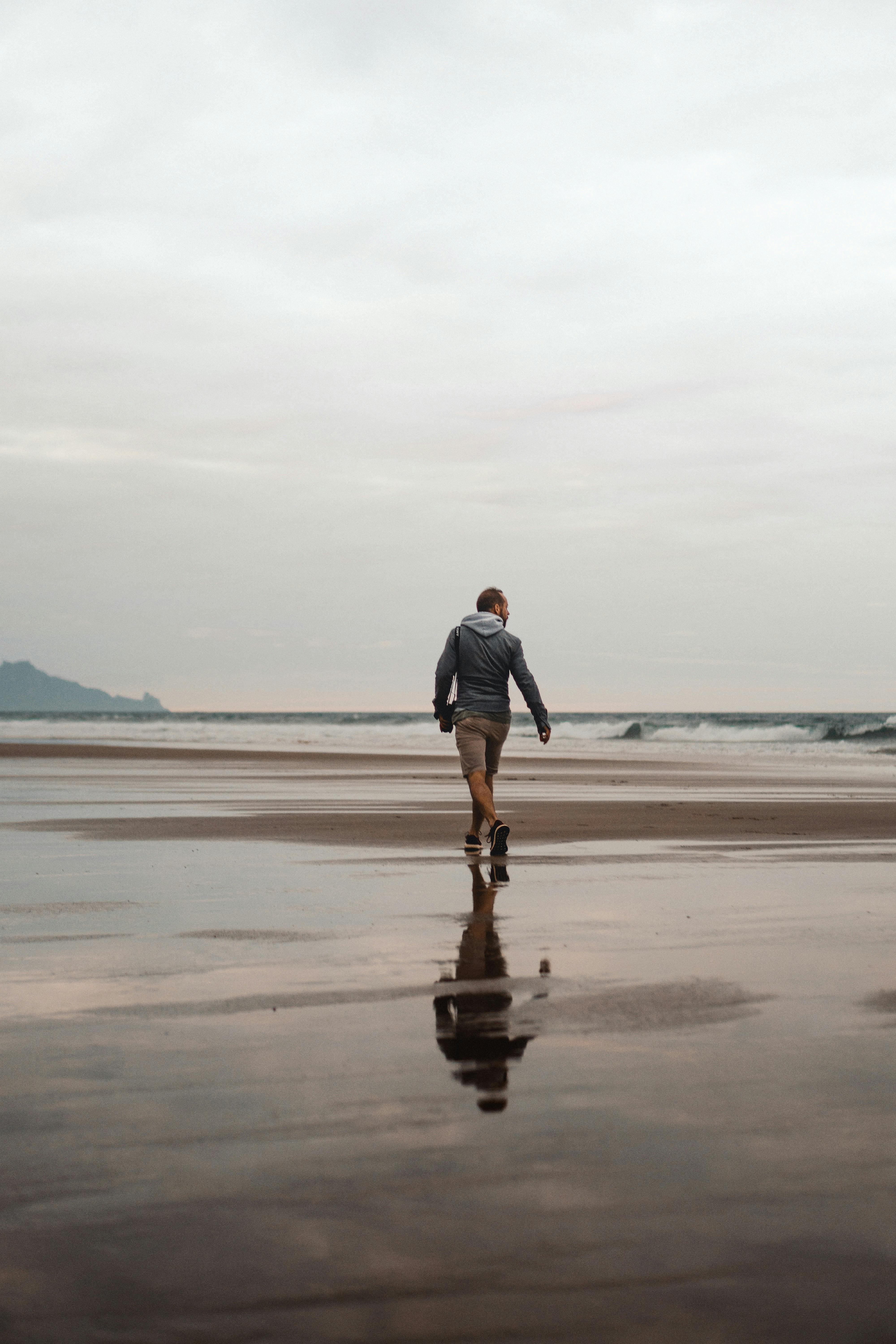 Back View of Man Walking on Beach · Free Stock Photo