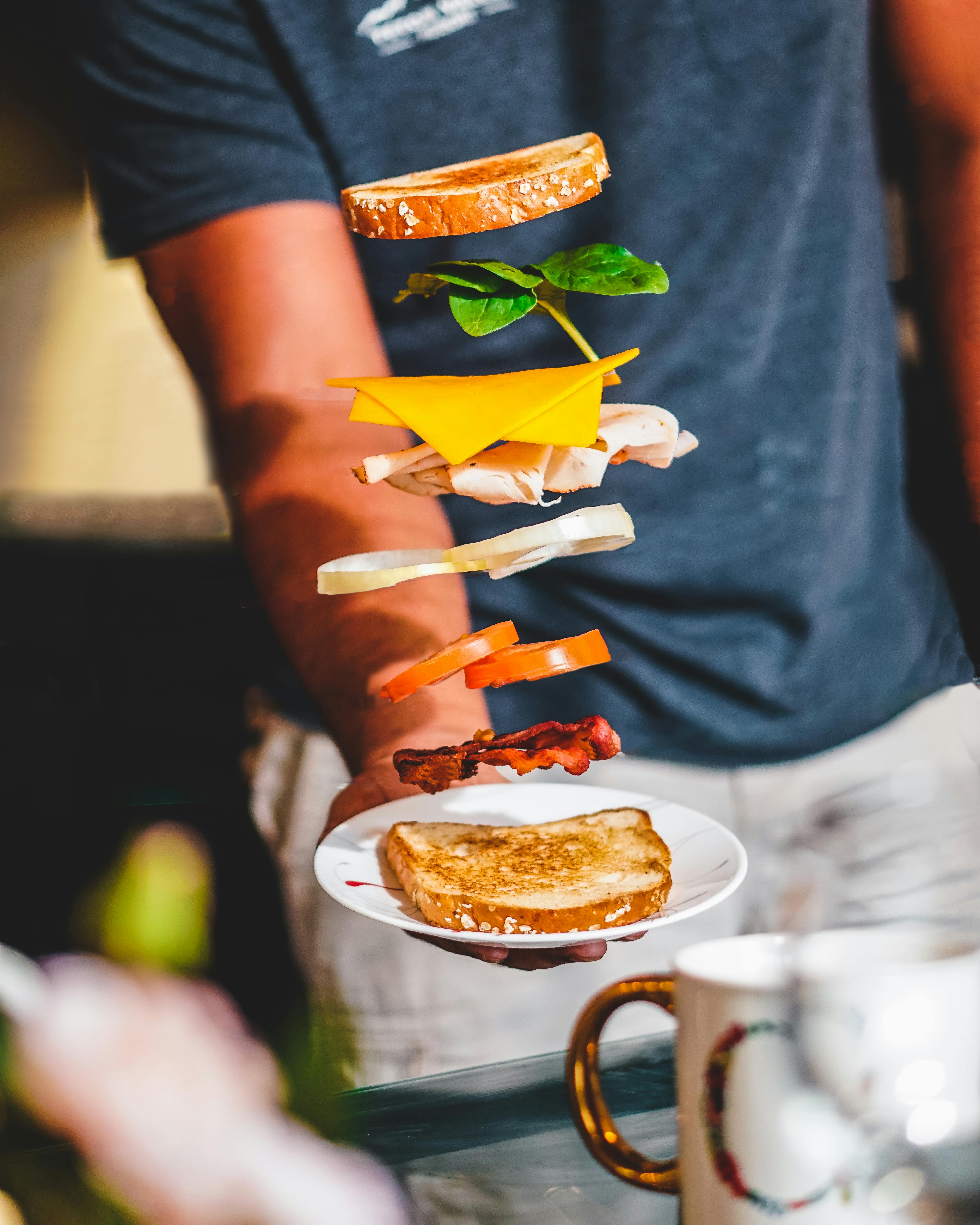 Crop male chef serving delicious sandwich · Free Stock Photo