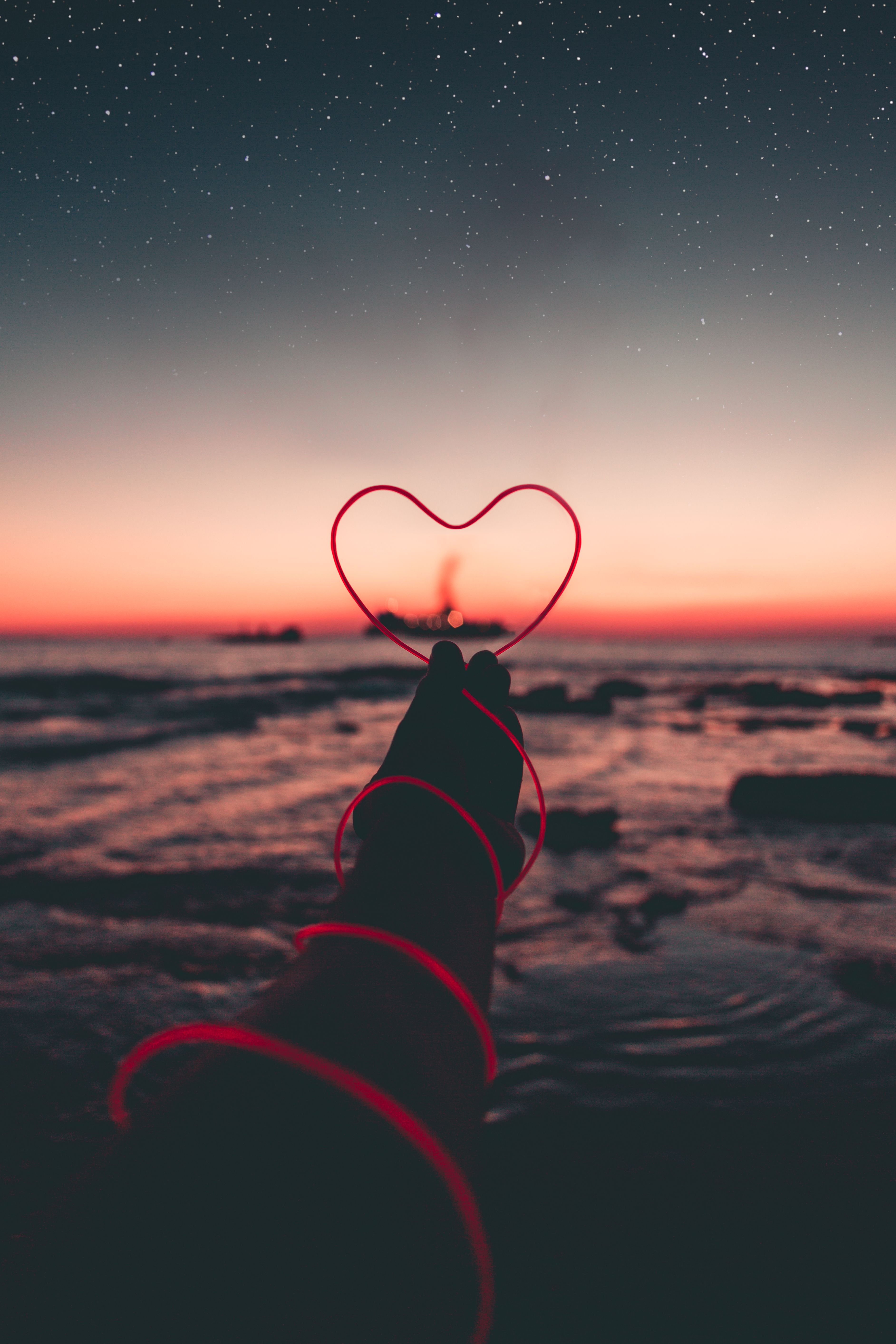 A Hand Holding a Heart-Shaped String · Free Stock Photo