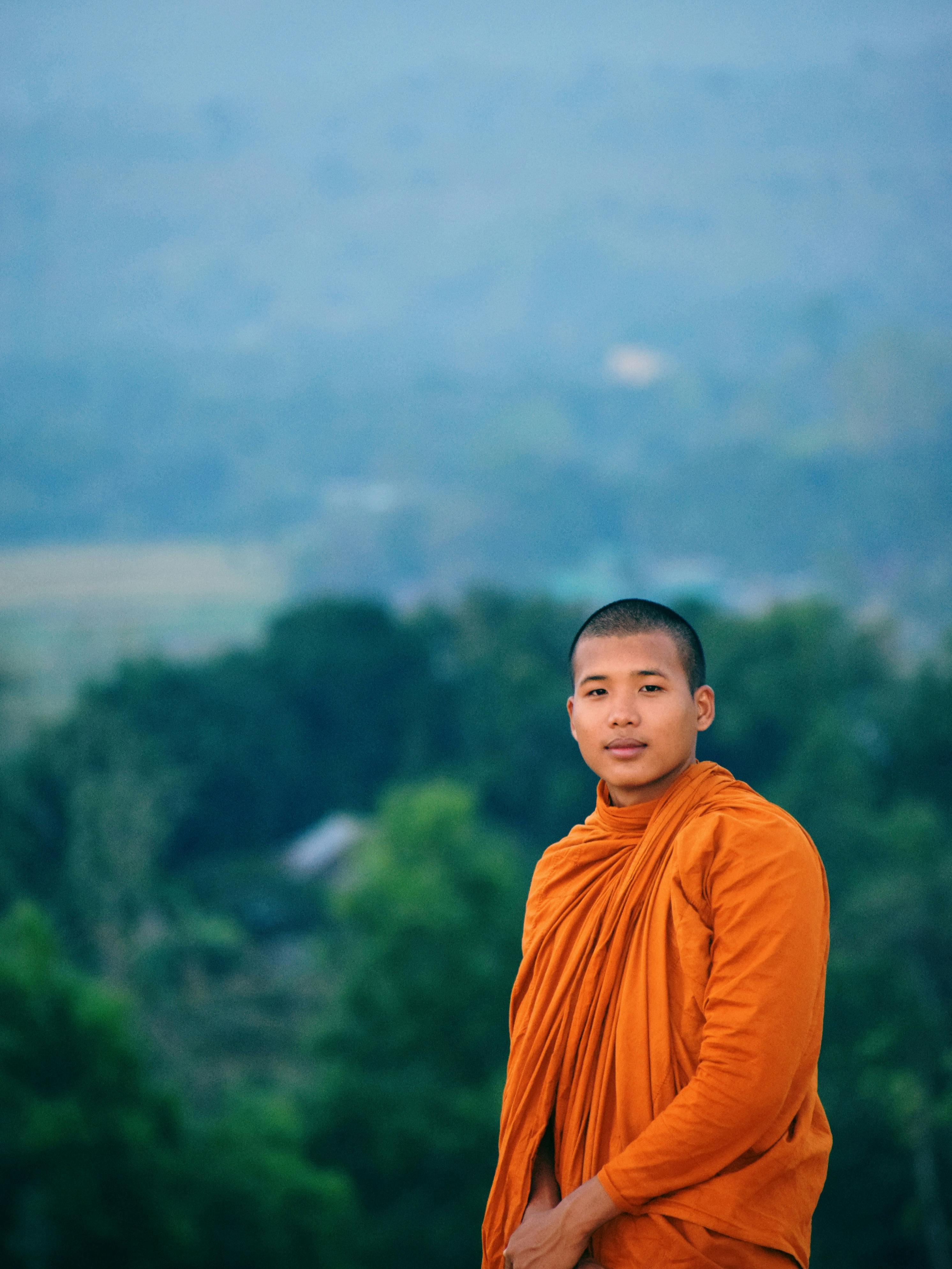 A Monk Sitting on a Tree Trunk · Free Stock Photo