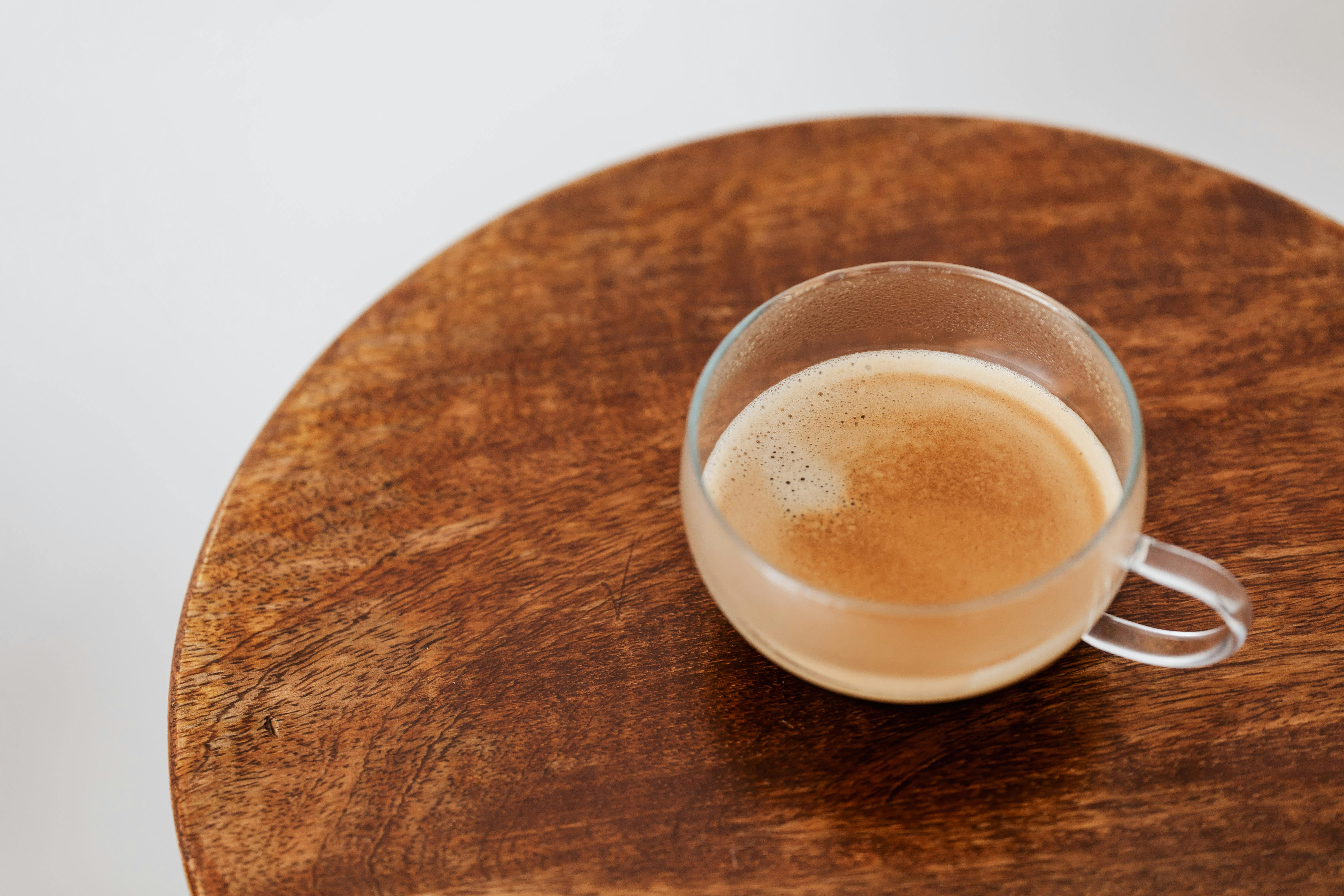 Cup of coffee standing on small round table · Free Stock Photo