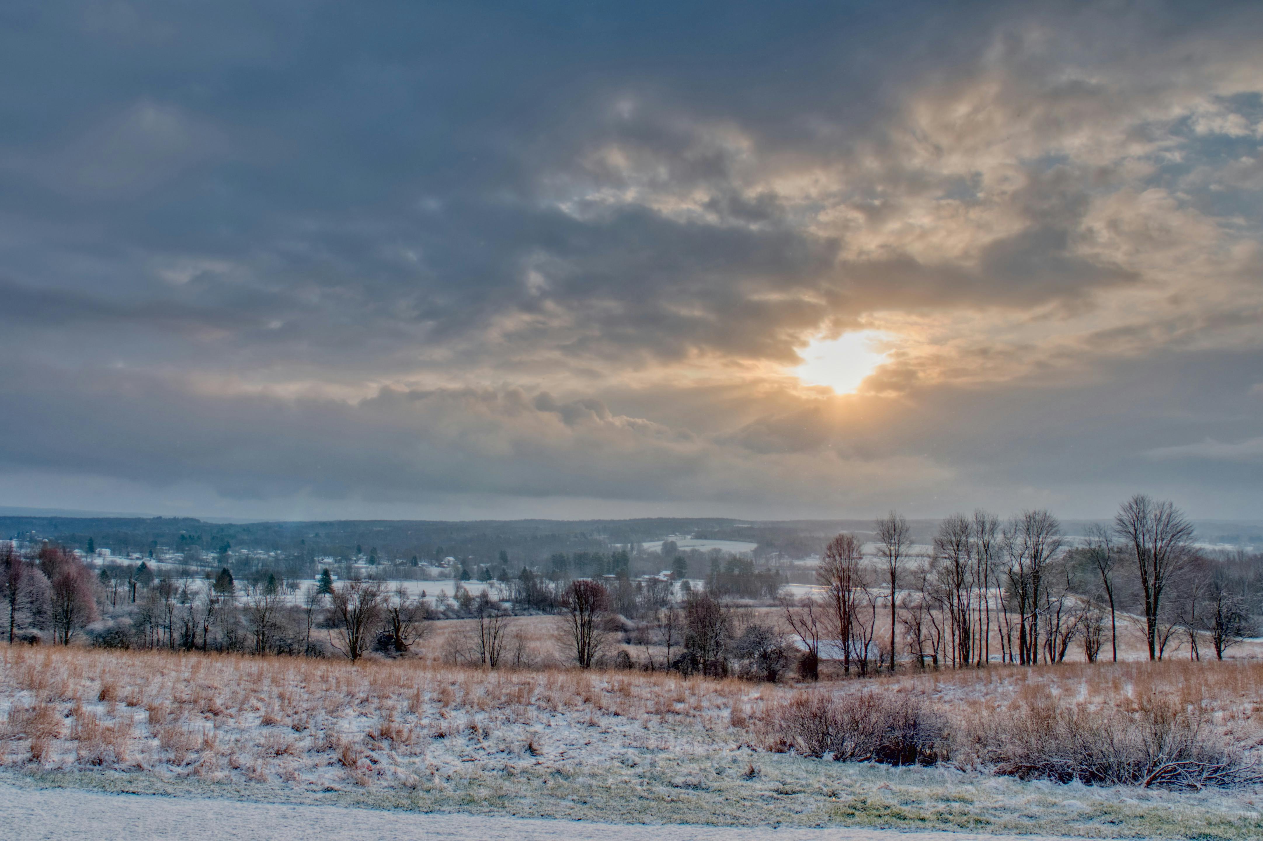 Shiny sun in sky above snowy terrain in twilight · Free Stock Photo