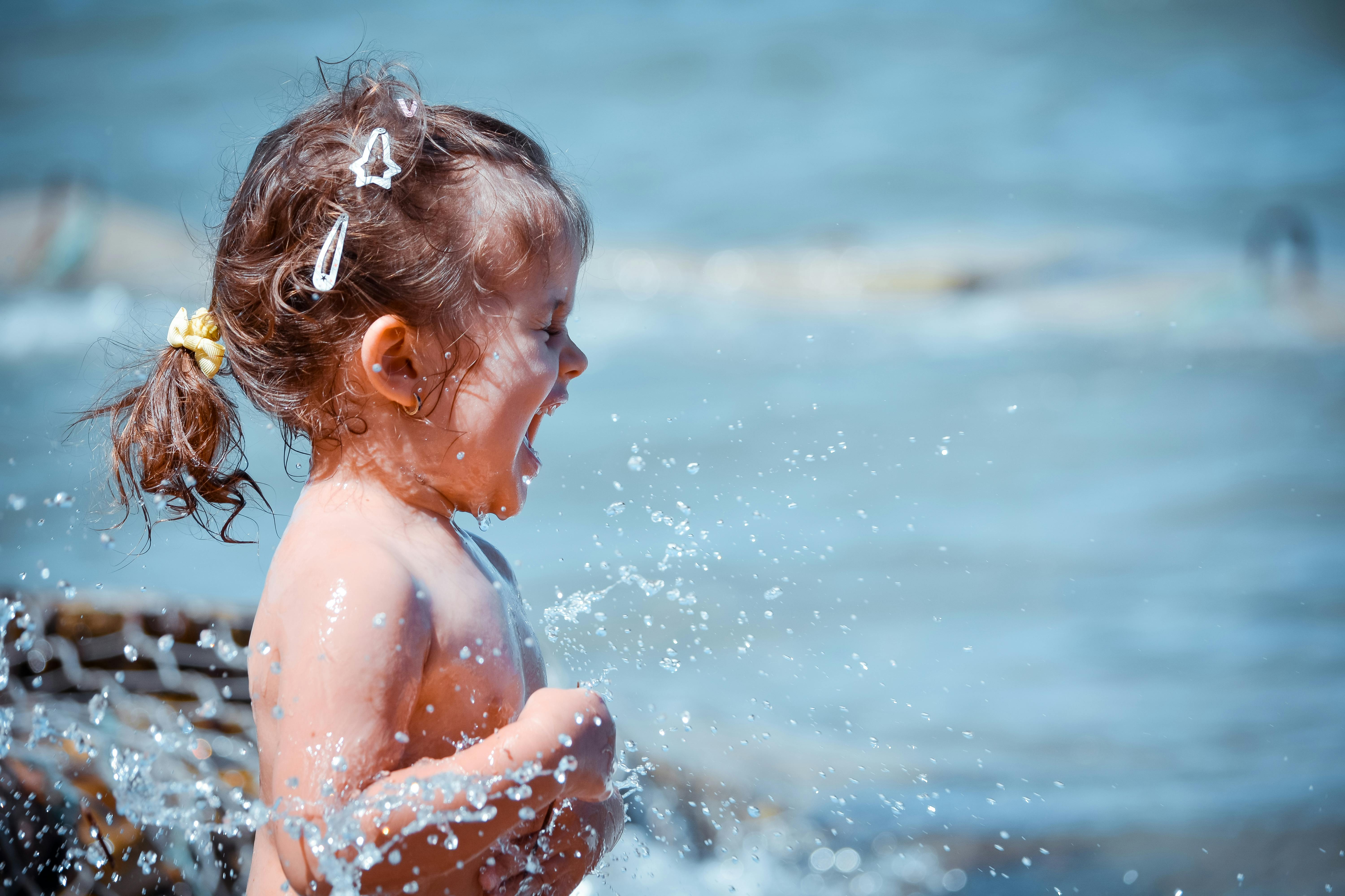 Wave Splashing on Cute Girl · Free Stock Photo