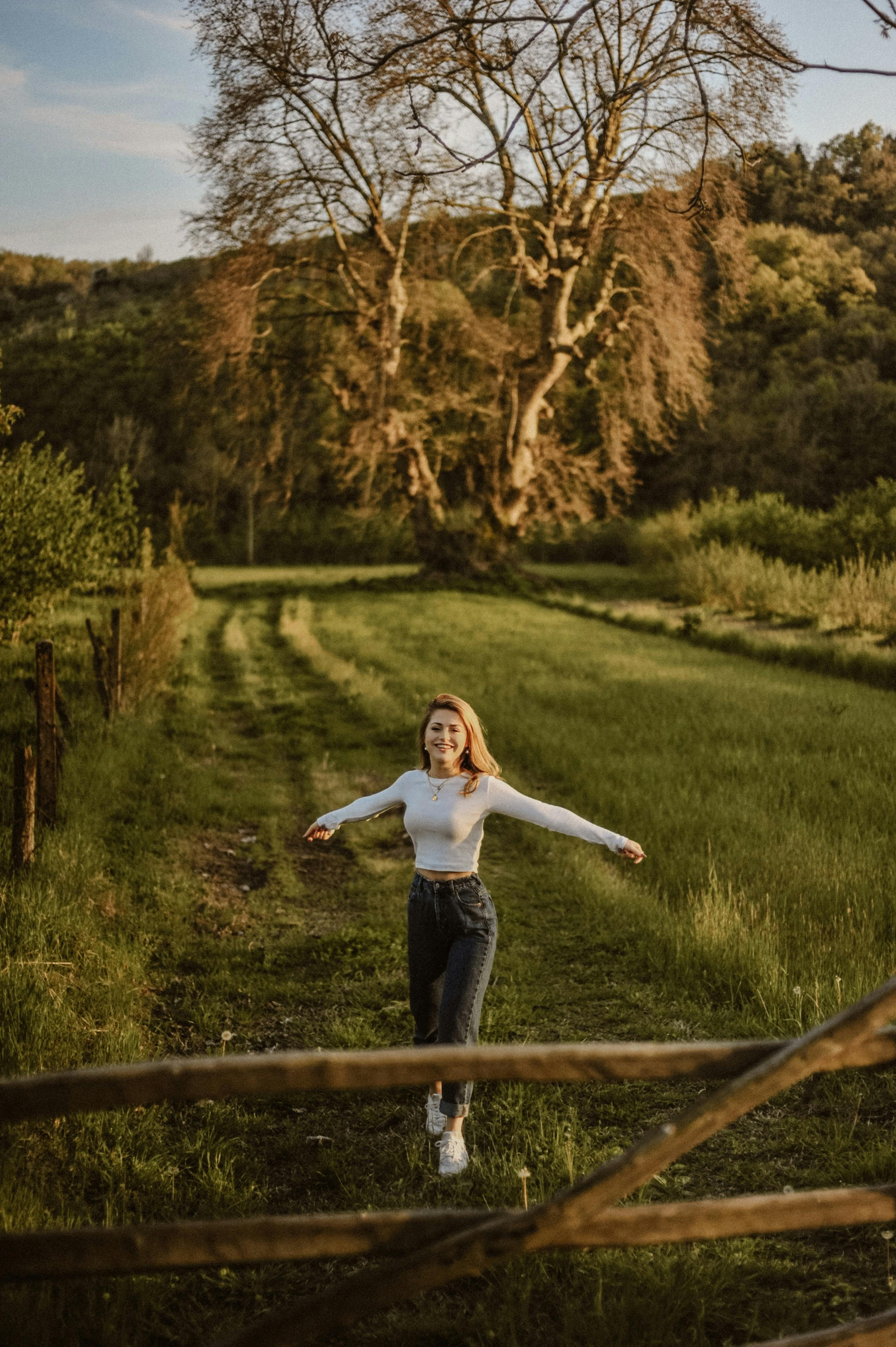 Cheerful woman on grass lawn in countryside · Free Stock Photo