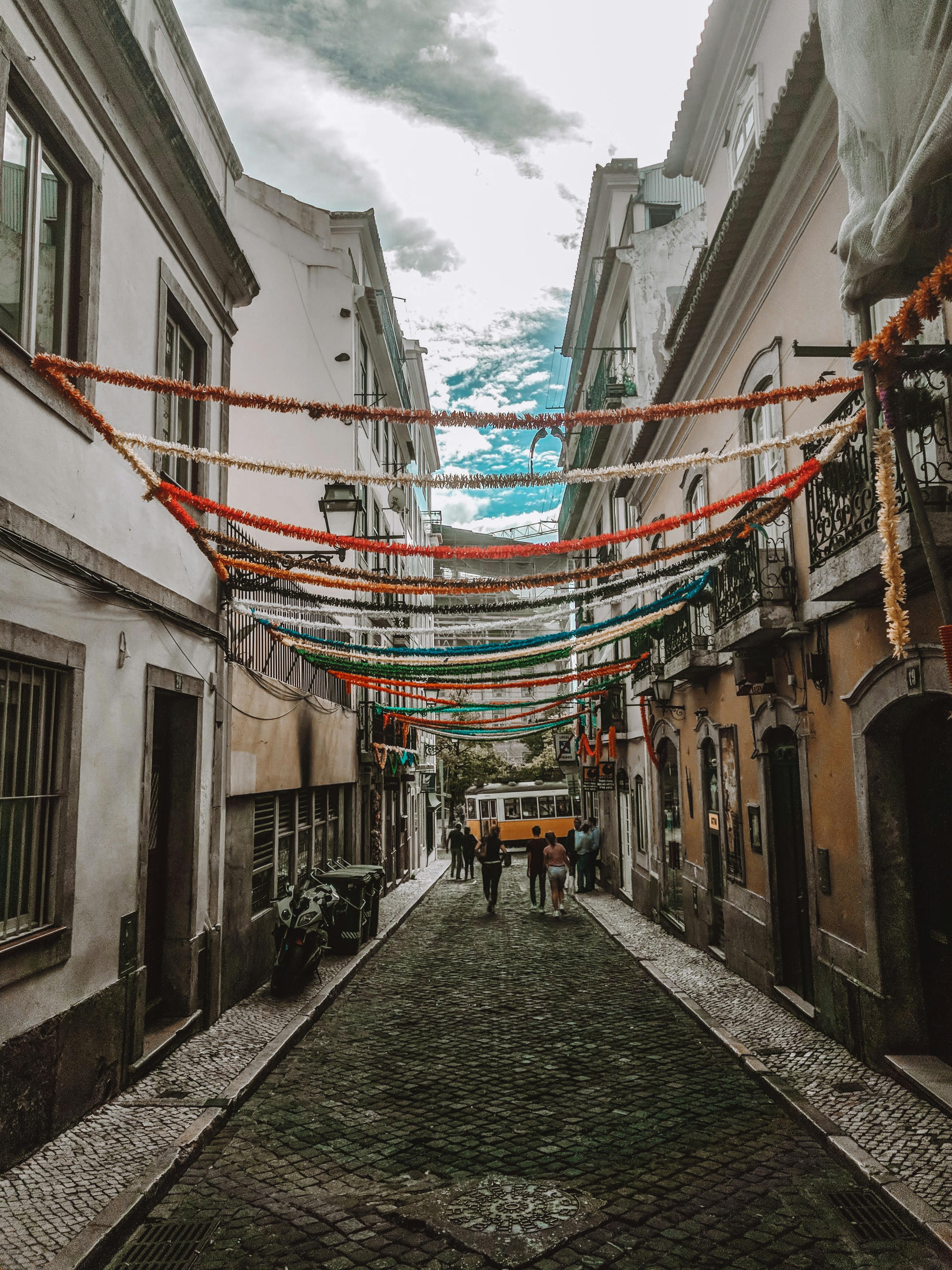 Narrow pedestrian street between residential buildings decorated with ...