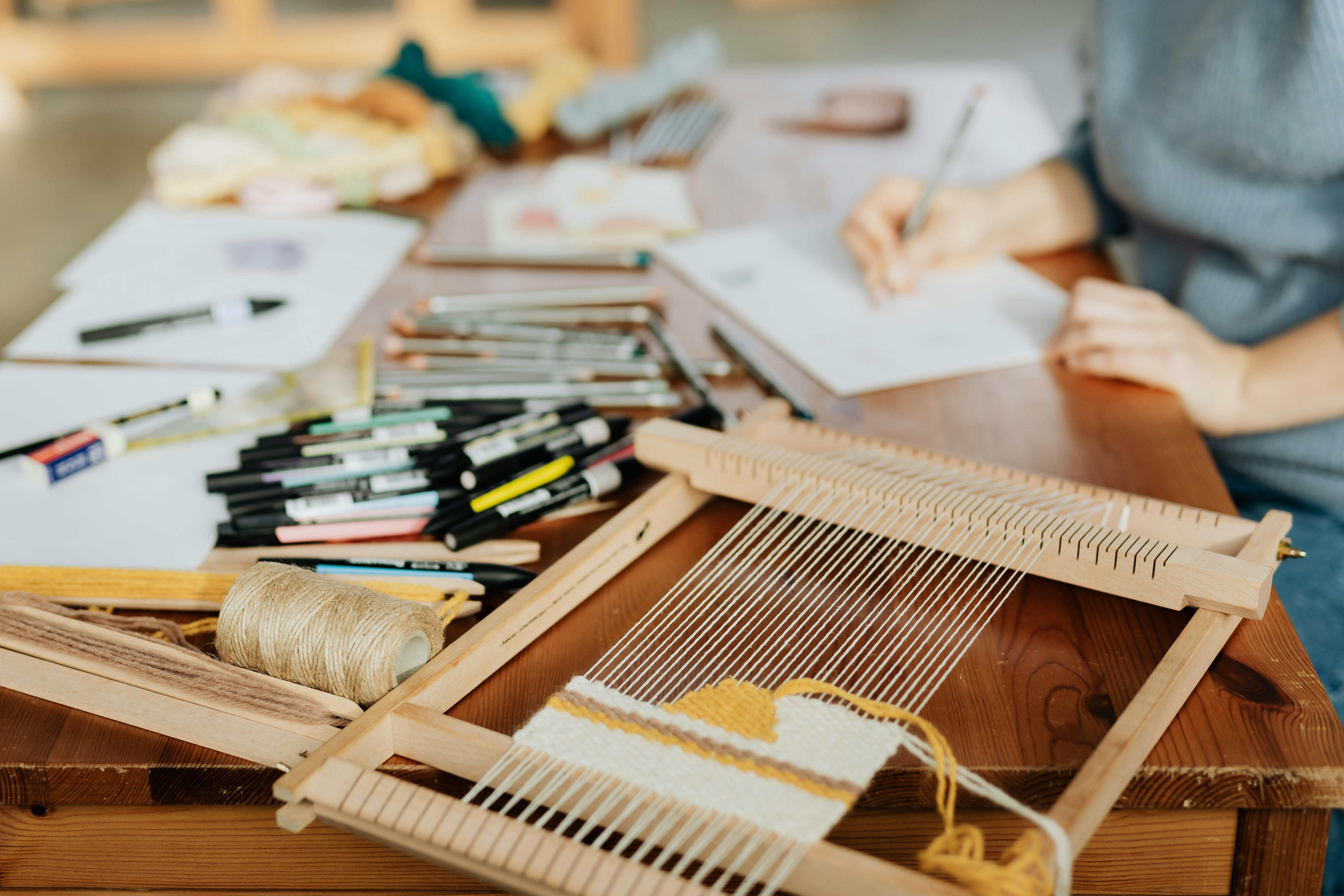 Crop anonymous craftswoman drawing near manual weaving loom machine ...
