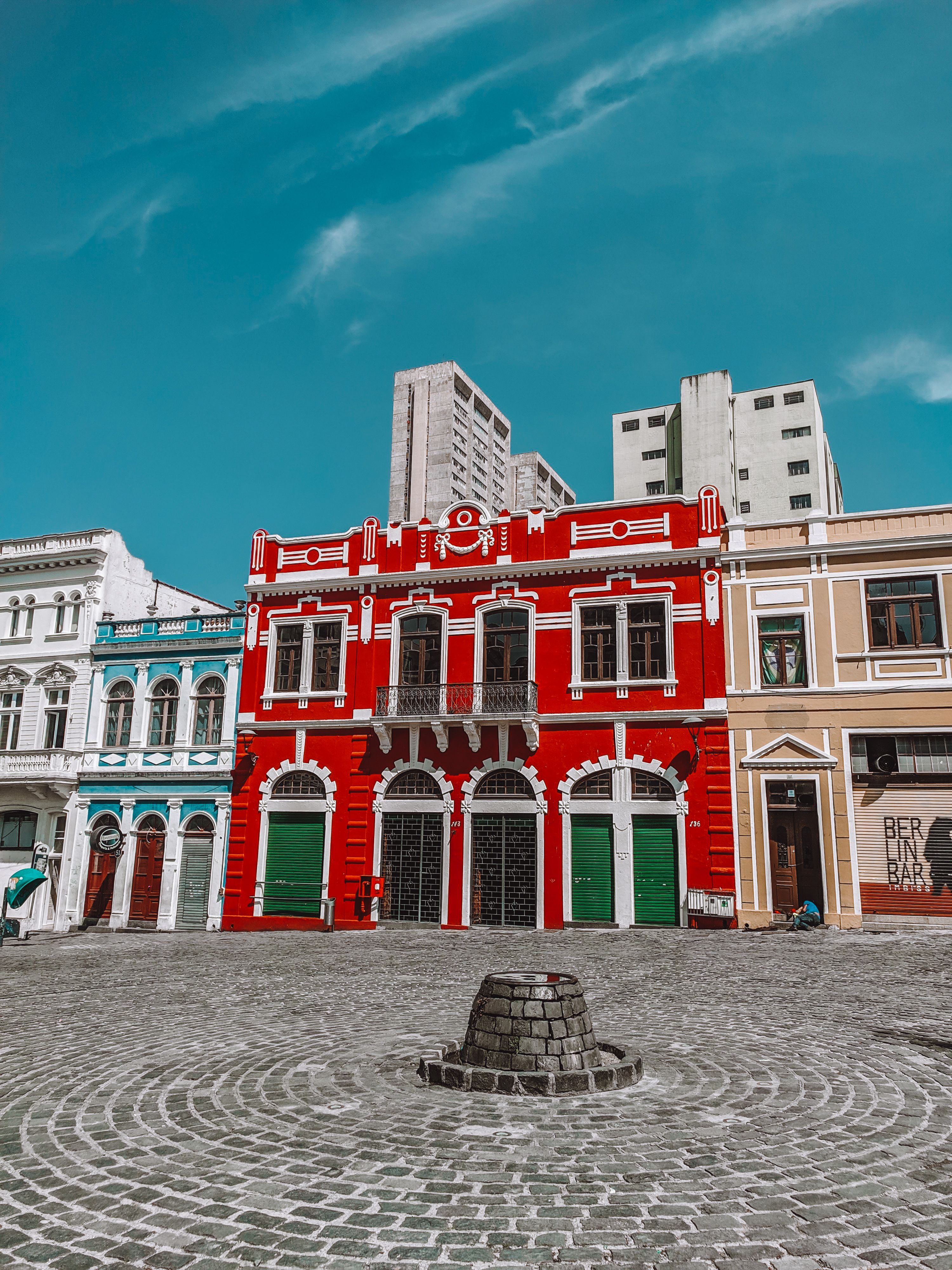 Red and White Concrete Building Under Blue Sky · Free Stock Photo