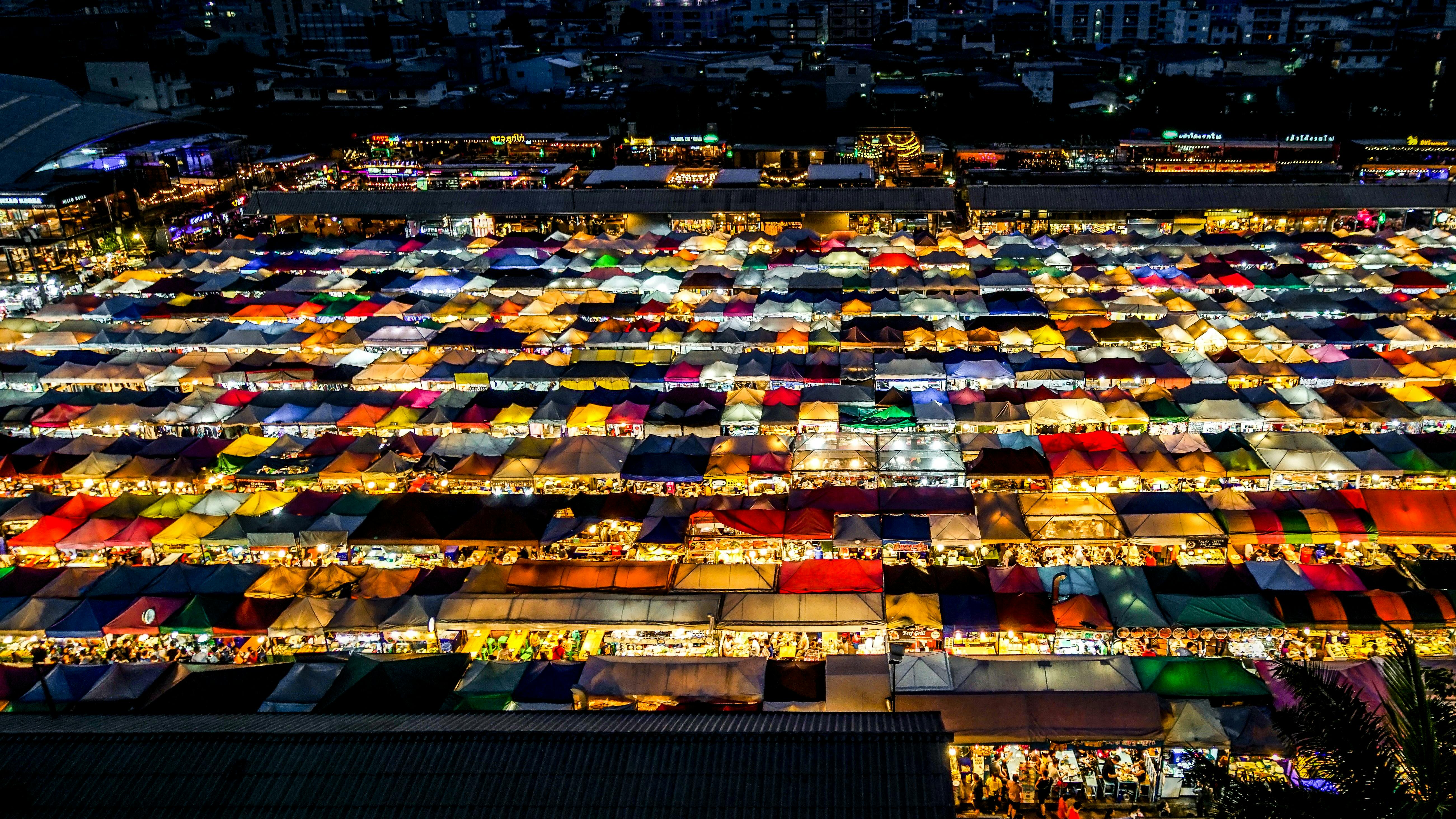 Illuminated Colorful Canopies of Night Market Stalls · Free Stock Photo