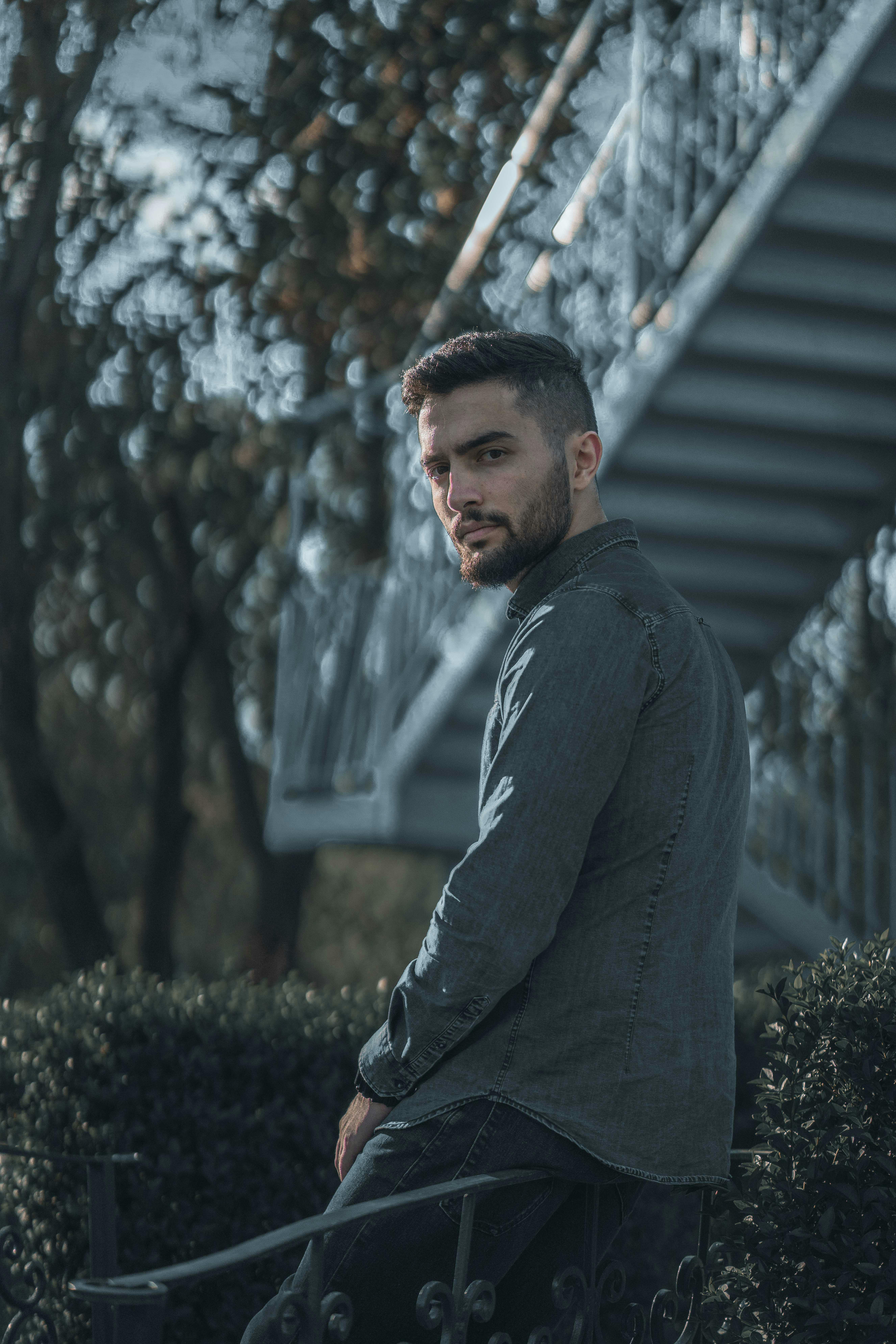 Man Posing Beside Metal Railing · Free Stock Photo