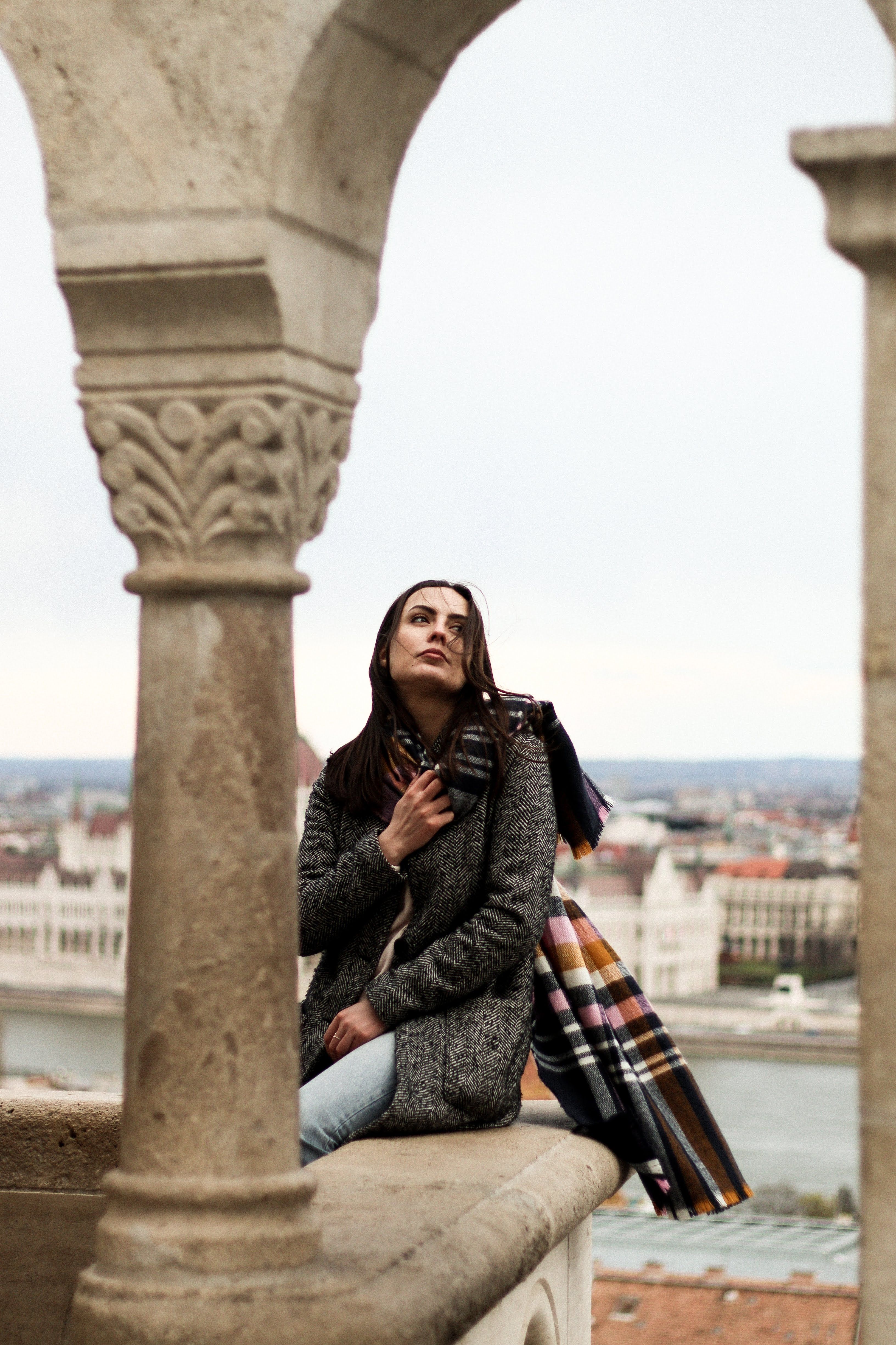 A Woman Wearing a Scarf Sitting on a Ledge · Free Stock Photo