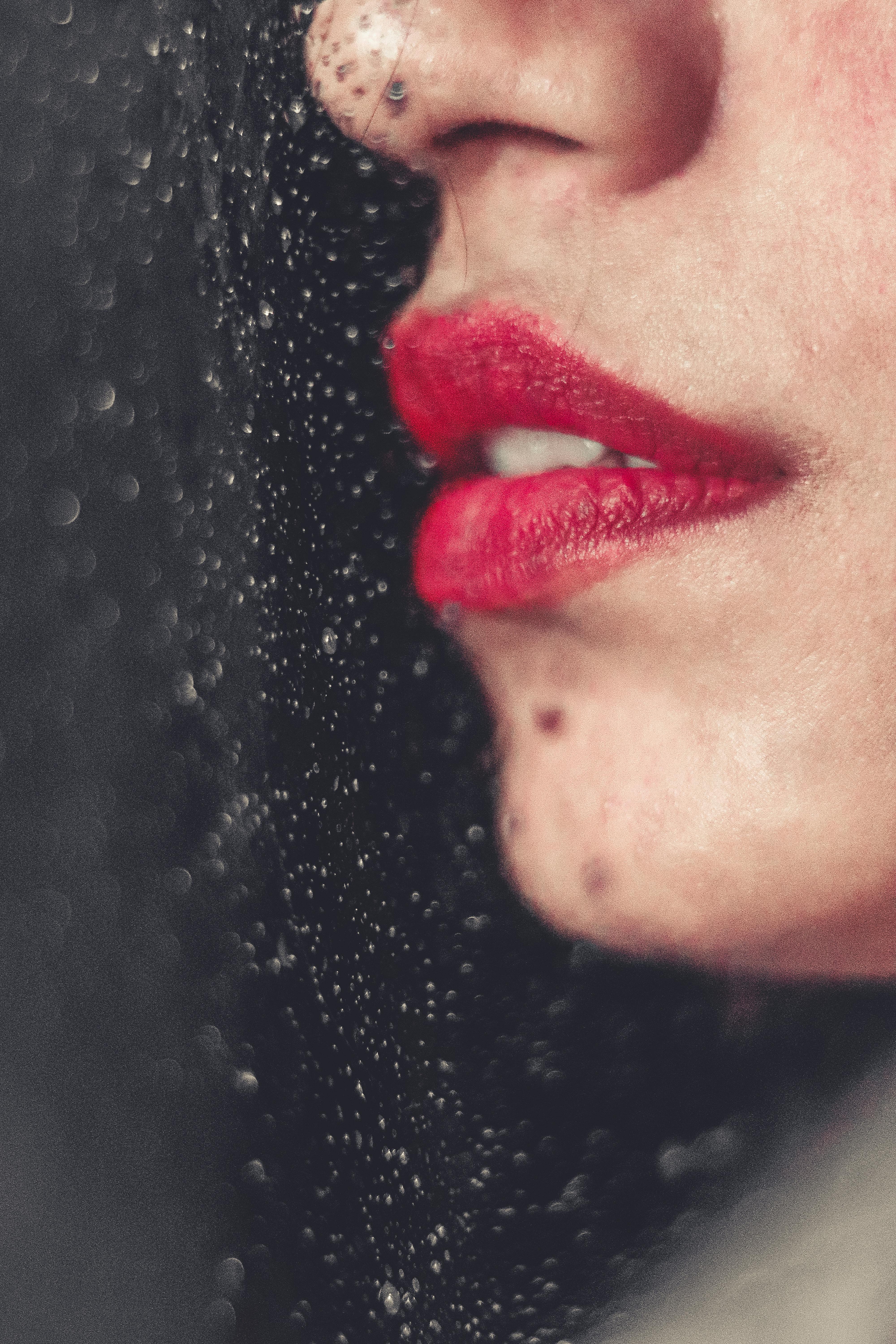 Woman with red lips and water drops falling down · Free Stock Photo