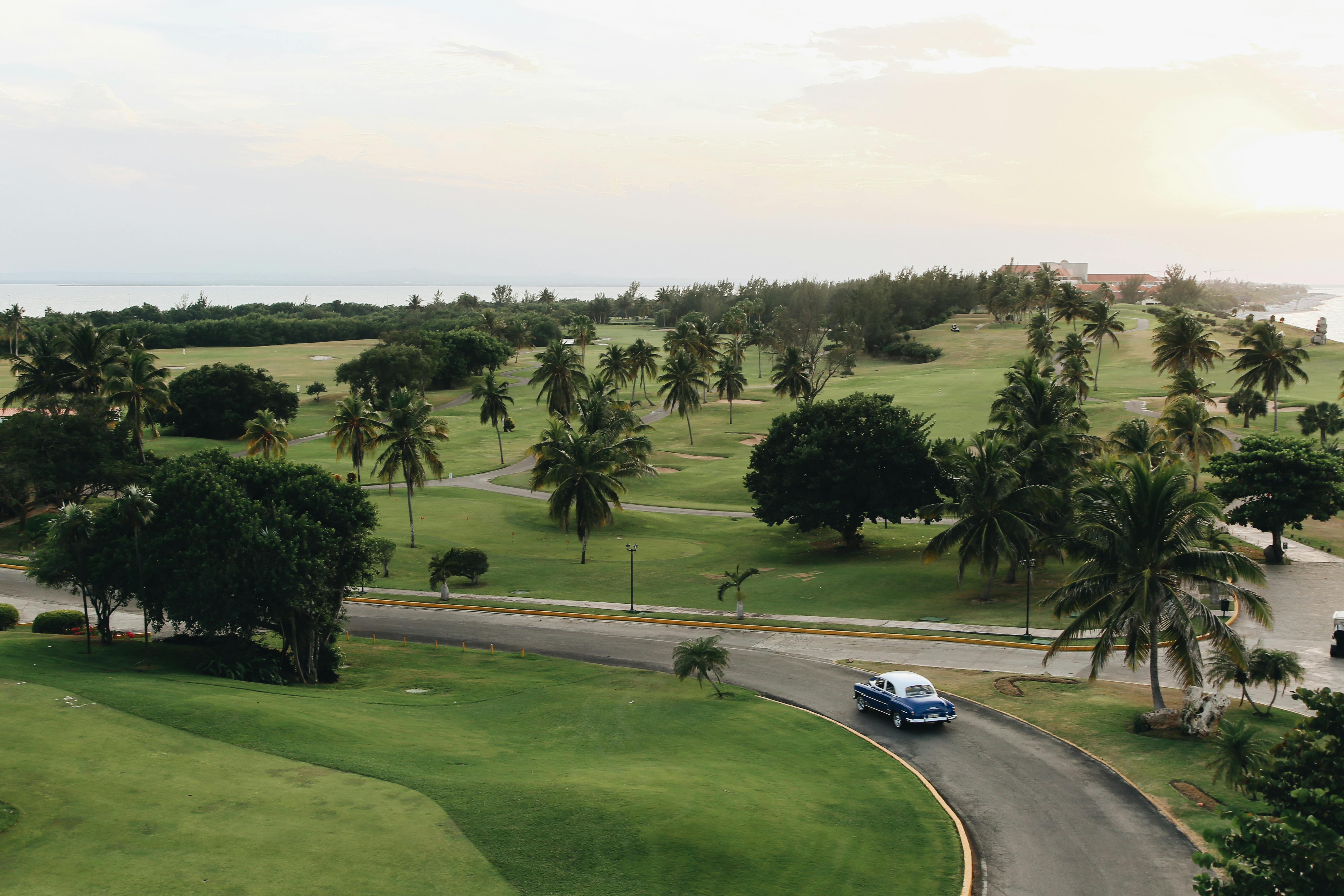 Vintage Car Passing Golf Course · Free Stock Photo