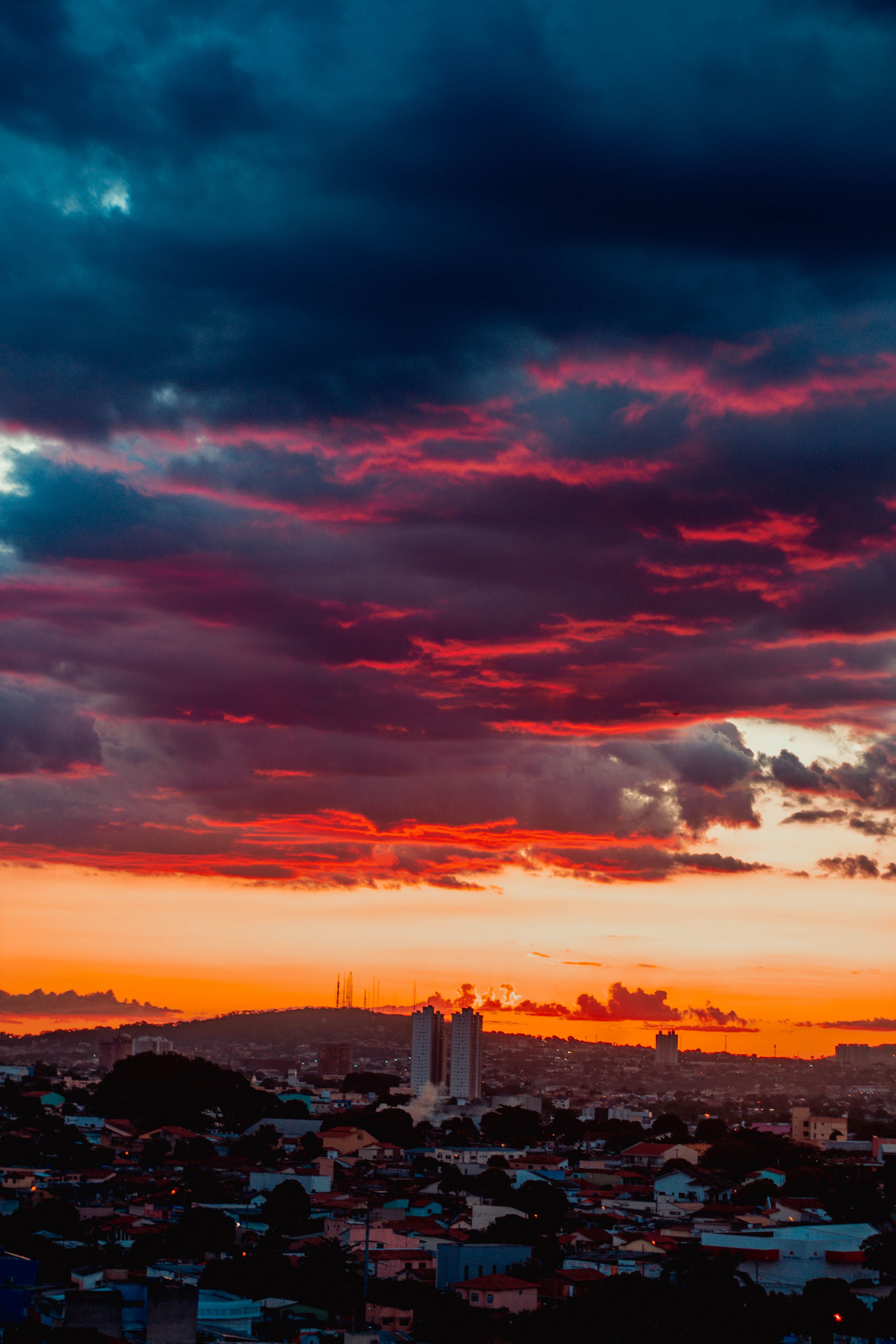 Dramatic sundown over mountains by settlement · Free Stock Photo