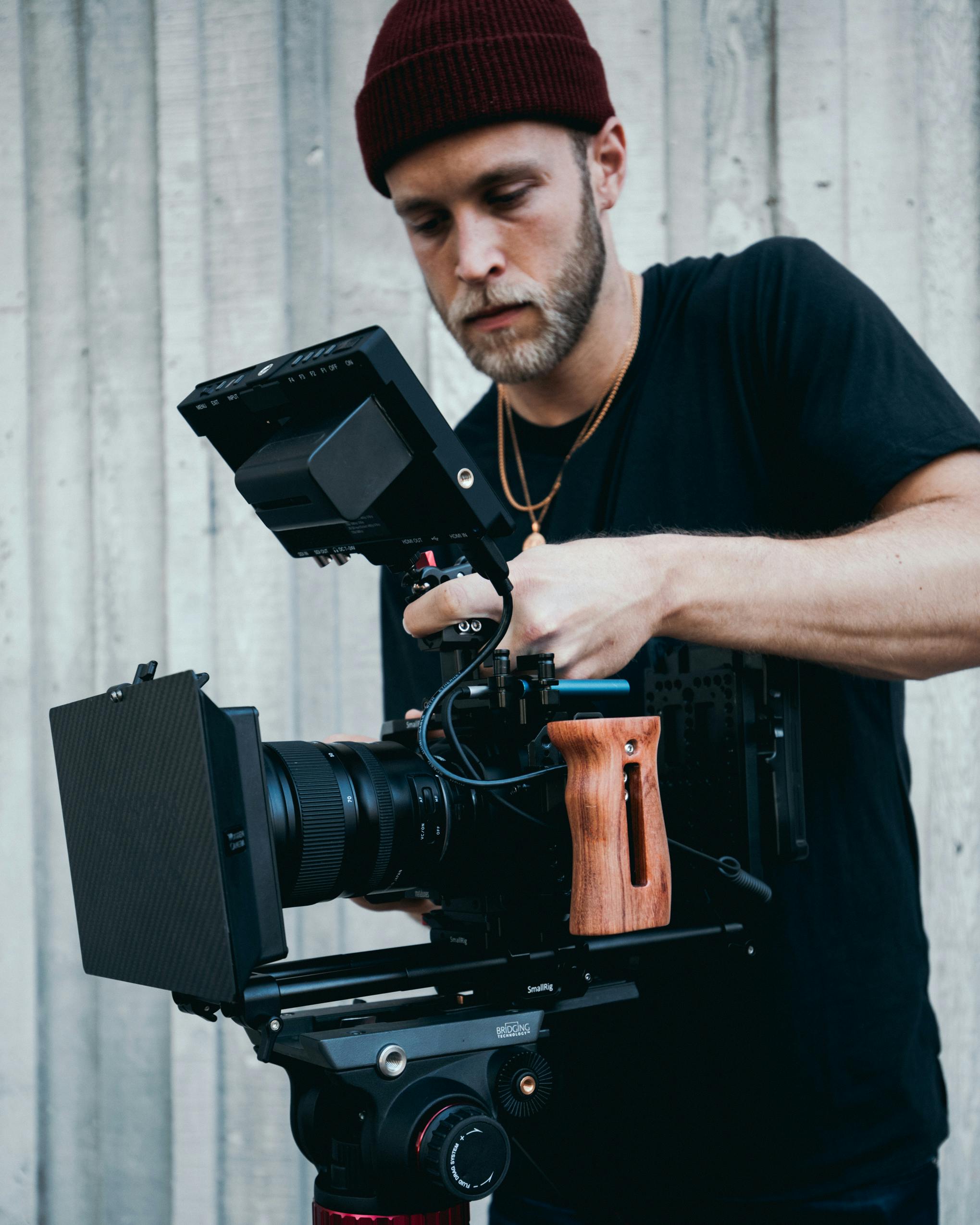 Close-Up Shot of a Camera Man Holding His Camera · Free Stock Photo