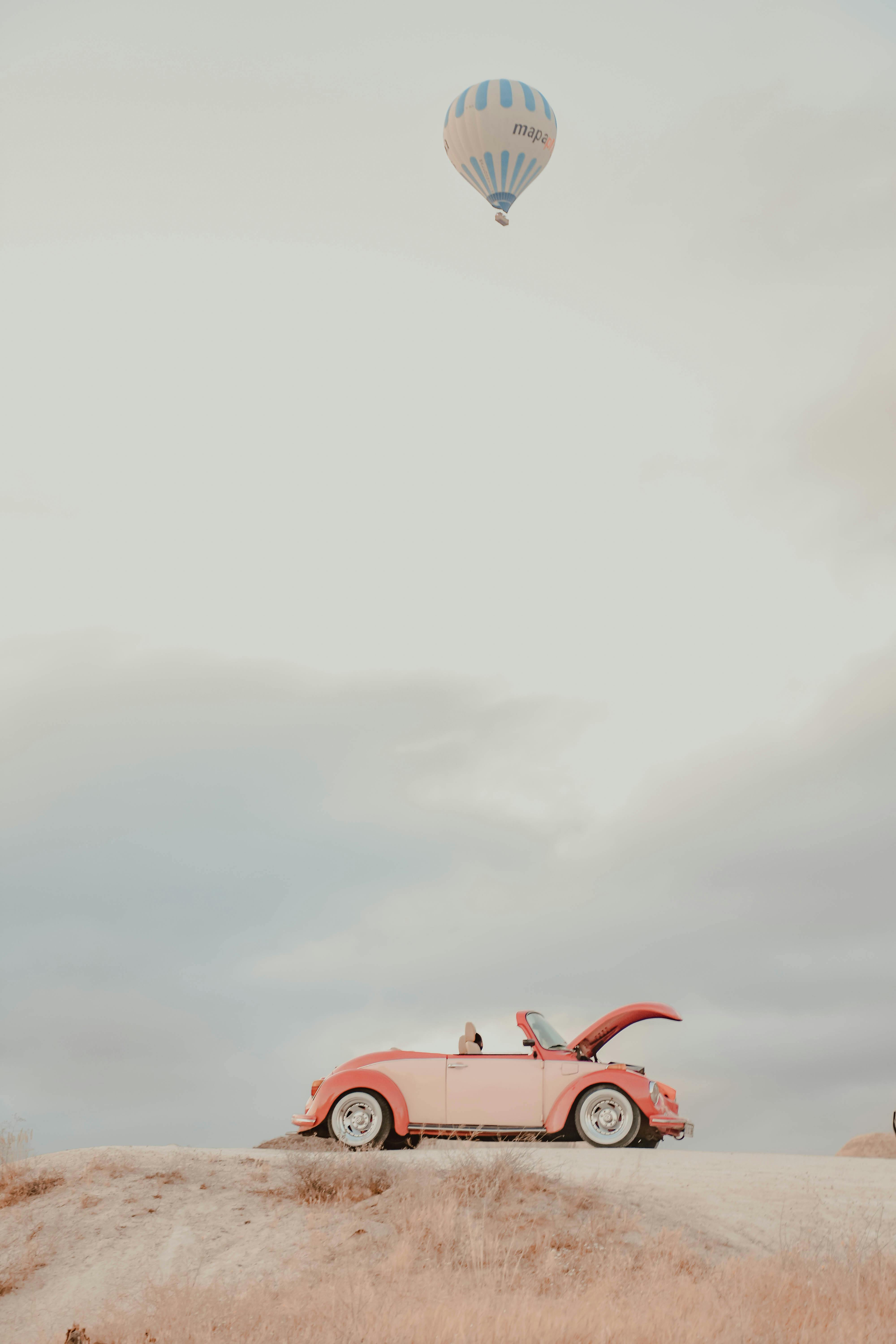Air balloon flying over vintage car · Free Stock Photo