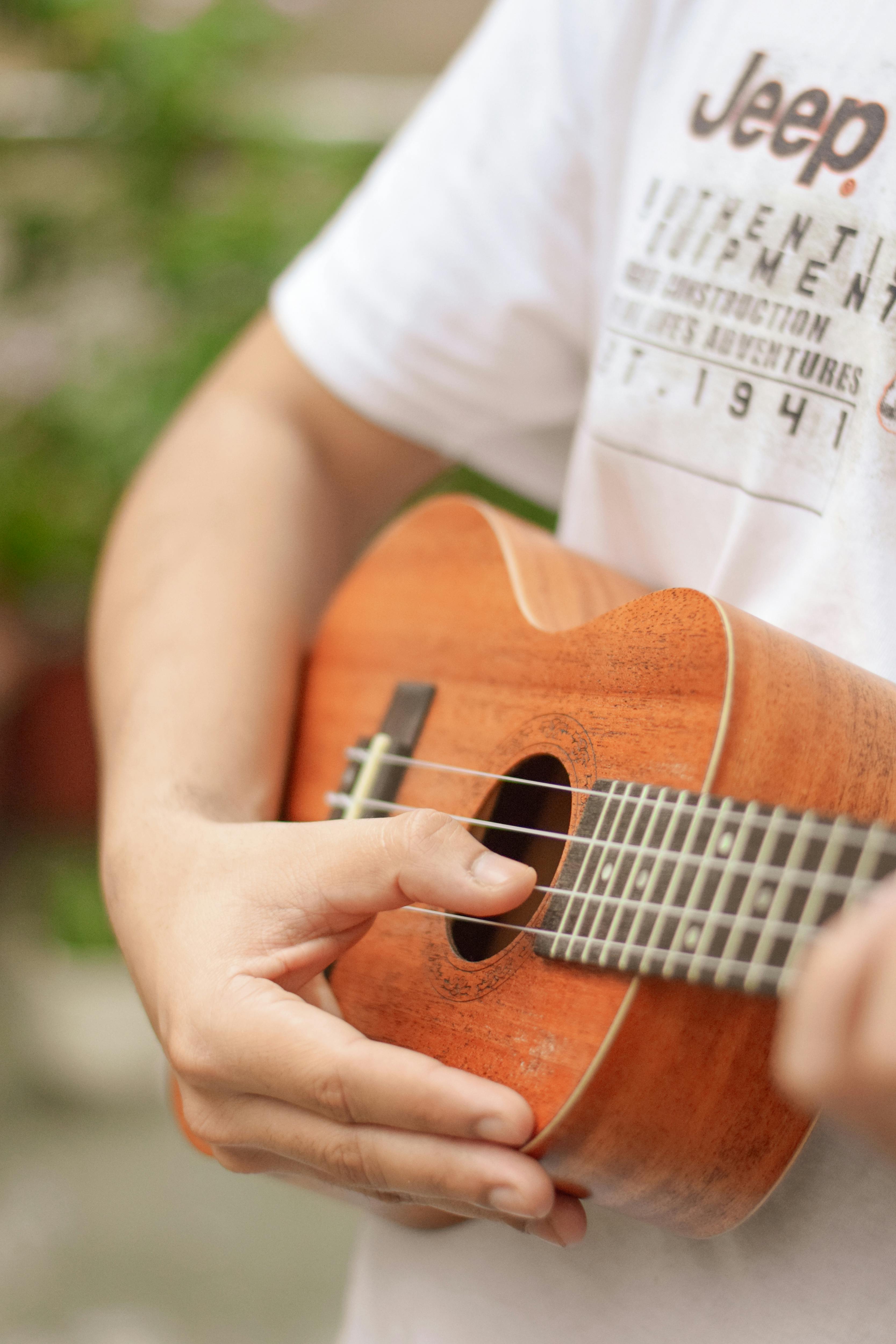 Anonymous person playing ukulele in park · Free Stock Photo