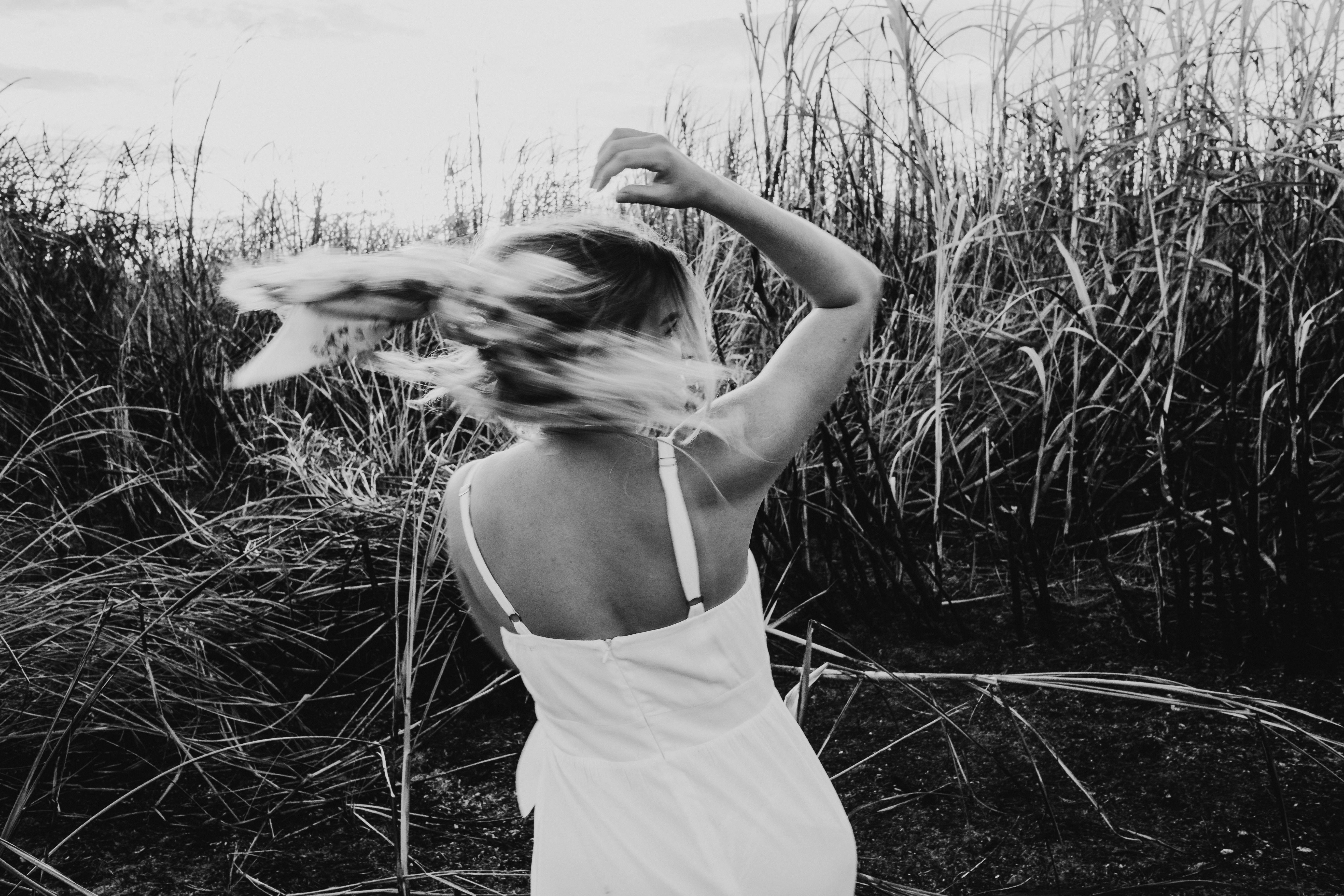 Anonymous woman shaking head in grassy field · Free Stock Photo