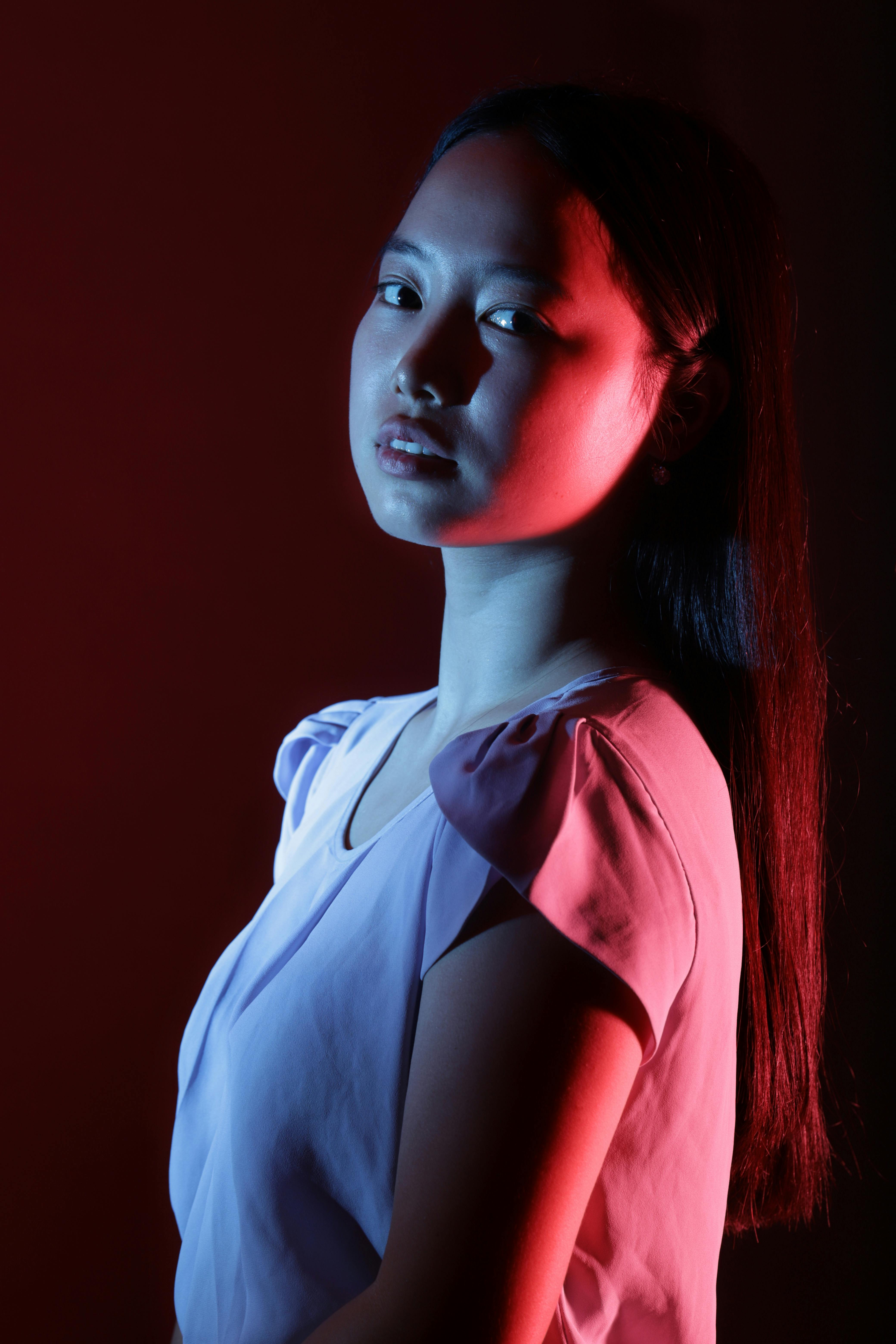 Young ethnic lady standing under neon illumination · Free Stock Photo
