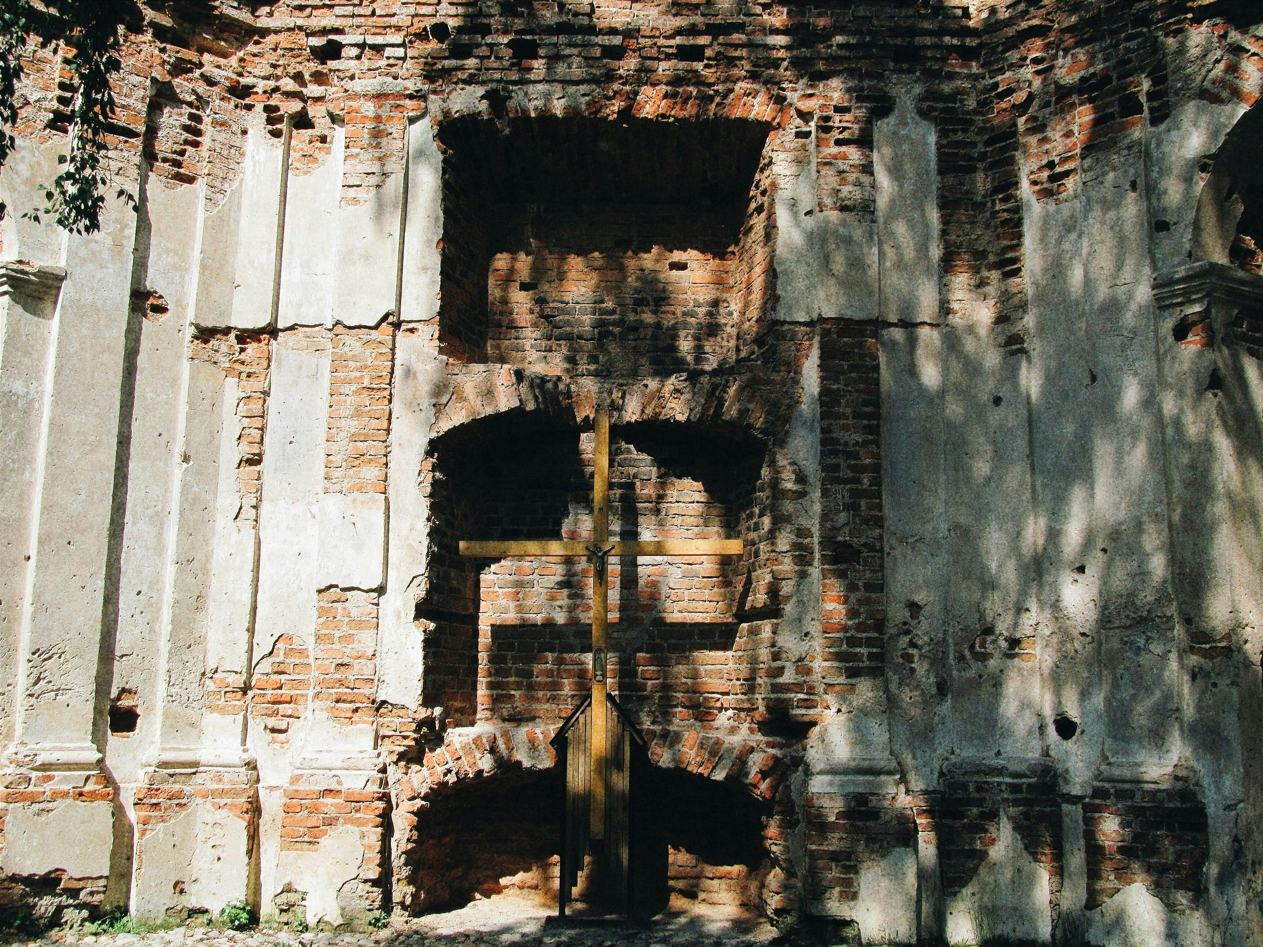 A Wooden Crucifix in front of a Brick Wall · Free Stock Photo