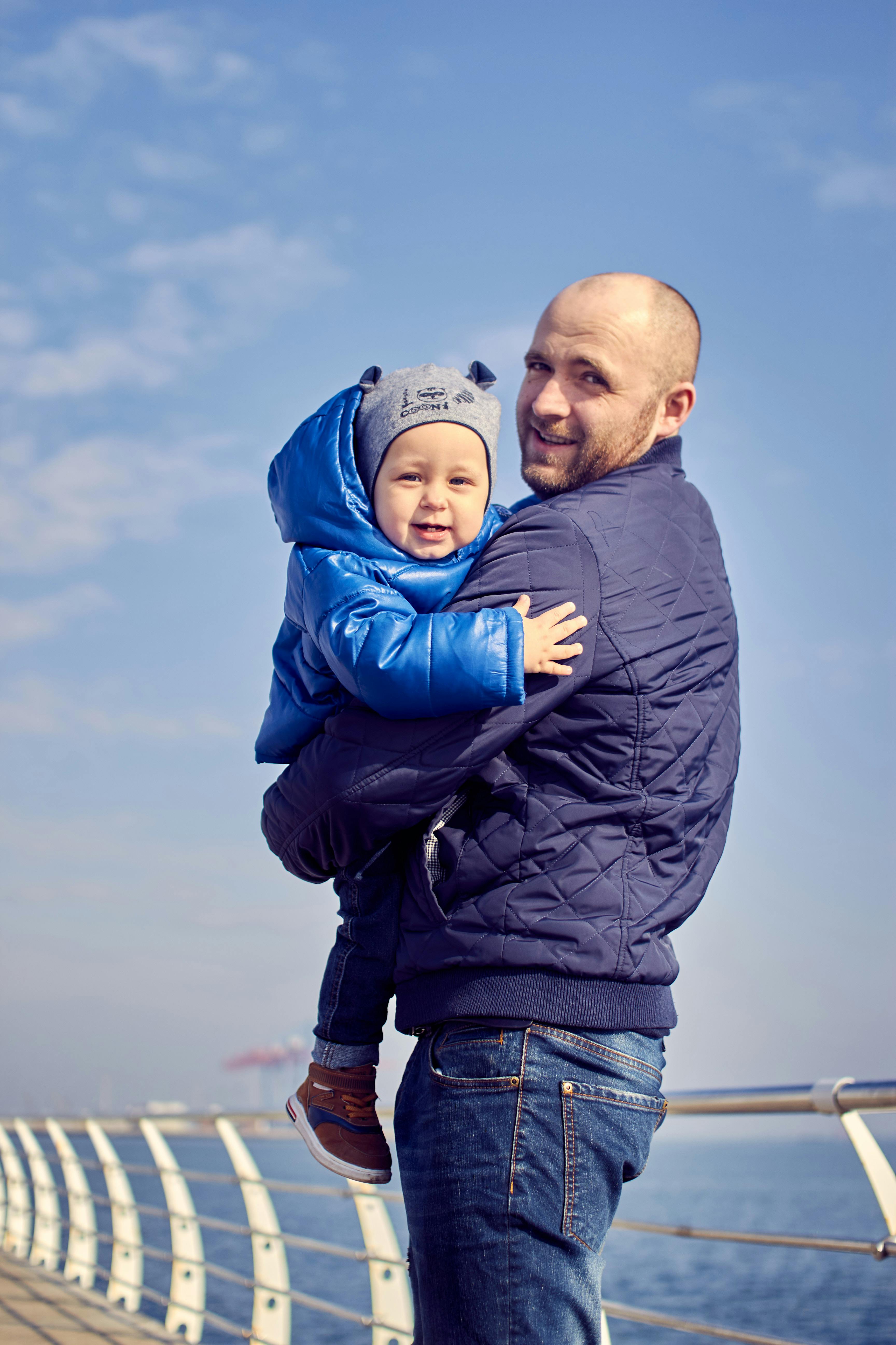 Photo of a Father Carrying His Child while Looking at the Camera · Free ...