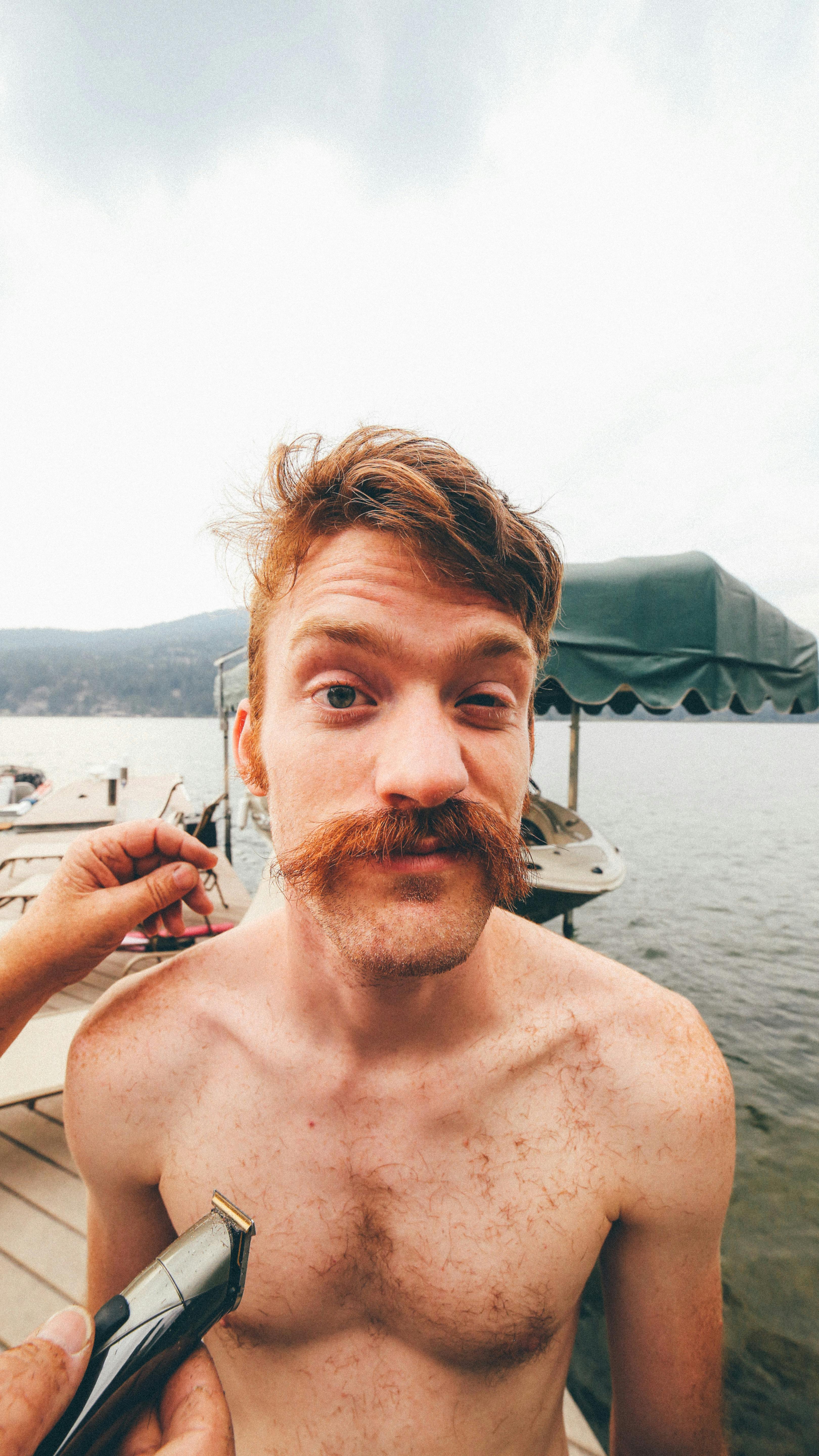 Hipster man with red mustache near unrecognizable barber · Free Stock Photo
