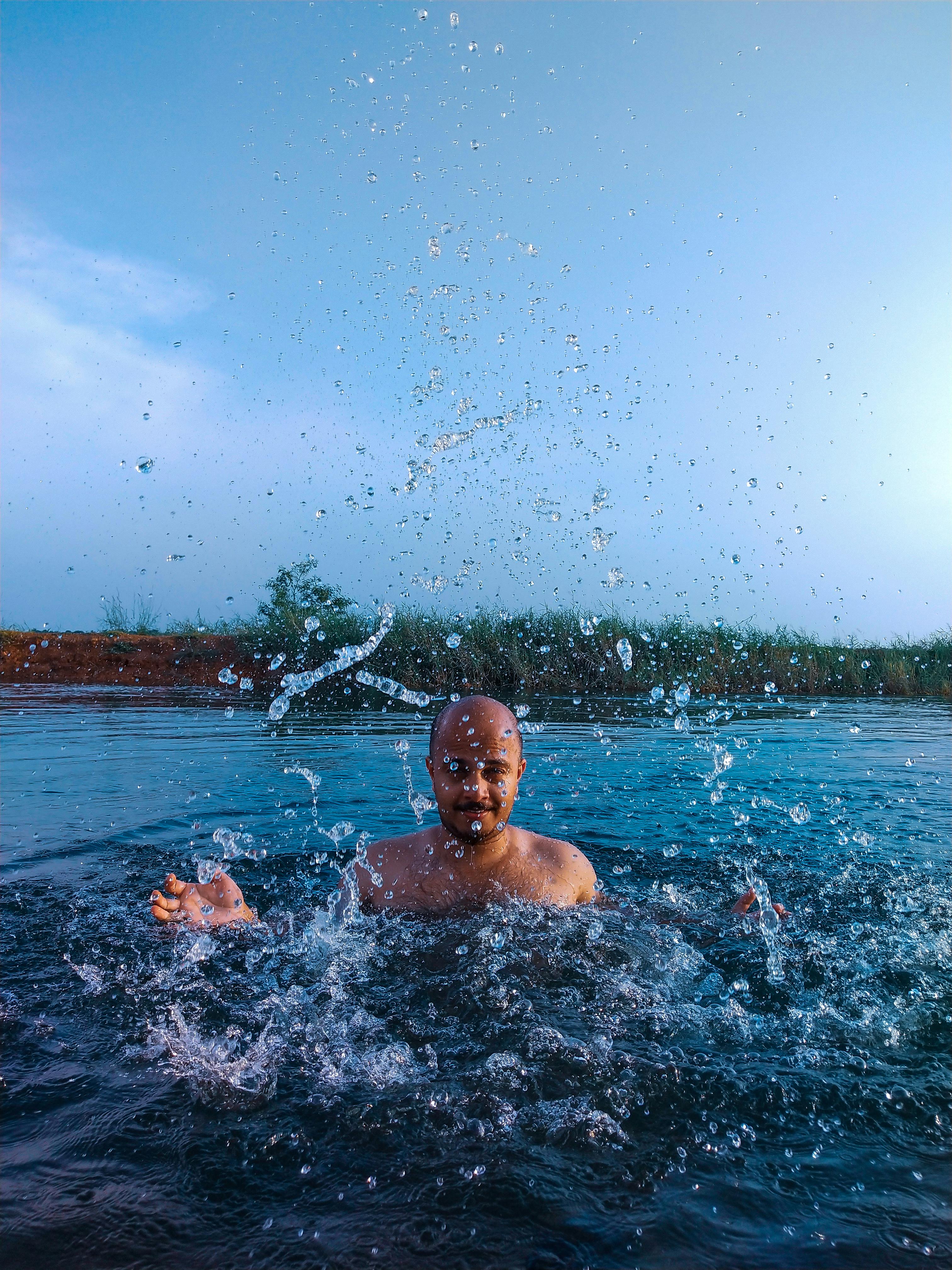 Man splashing water in lake in countryside · Free Stock Photo