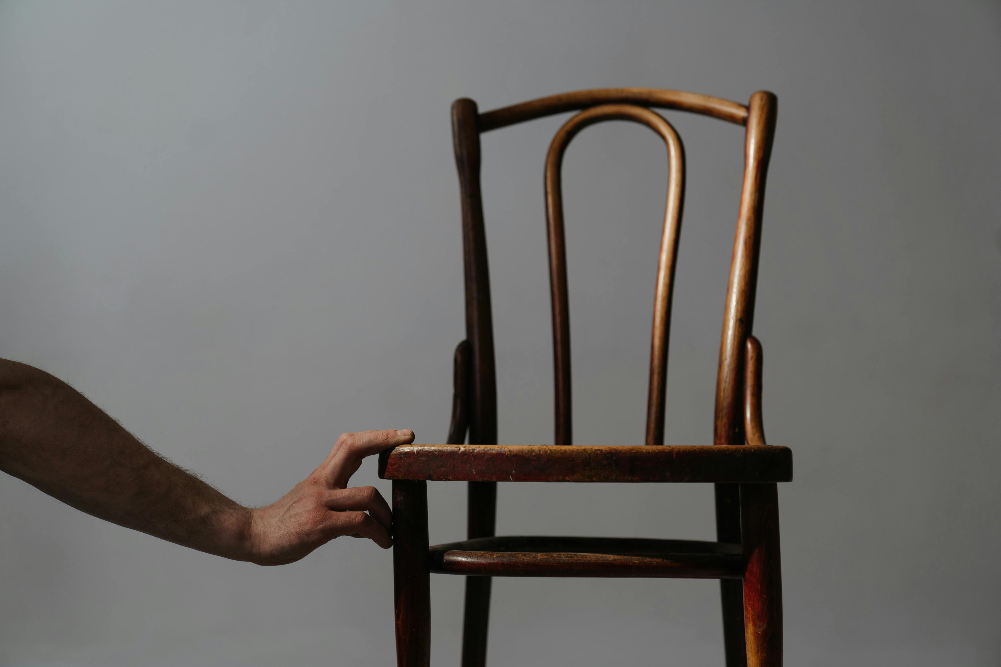 Person Sitting on Brown Wooden Chair · Free Stock Photo