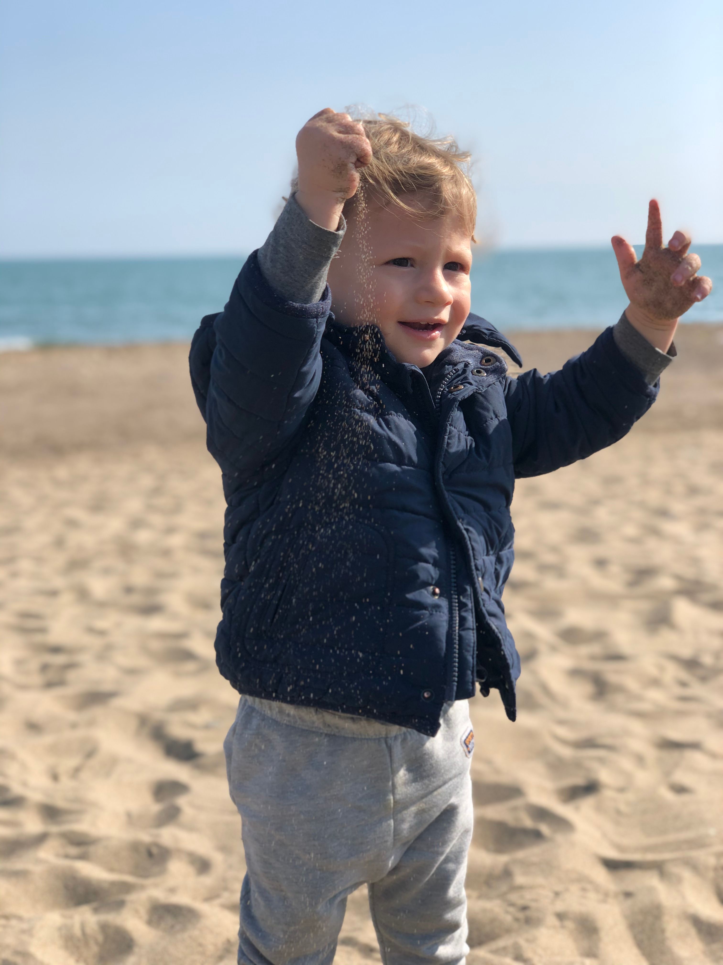 Boy in Black Jacket Standing on Beach · Free Stock Photo