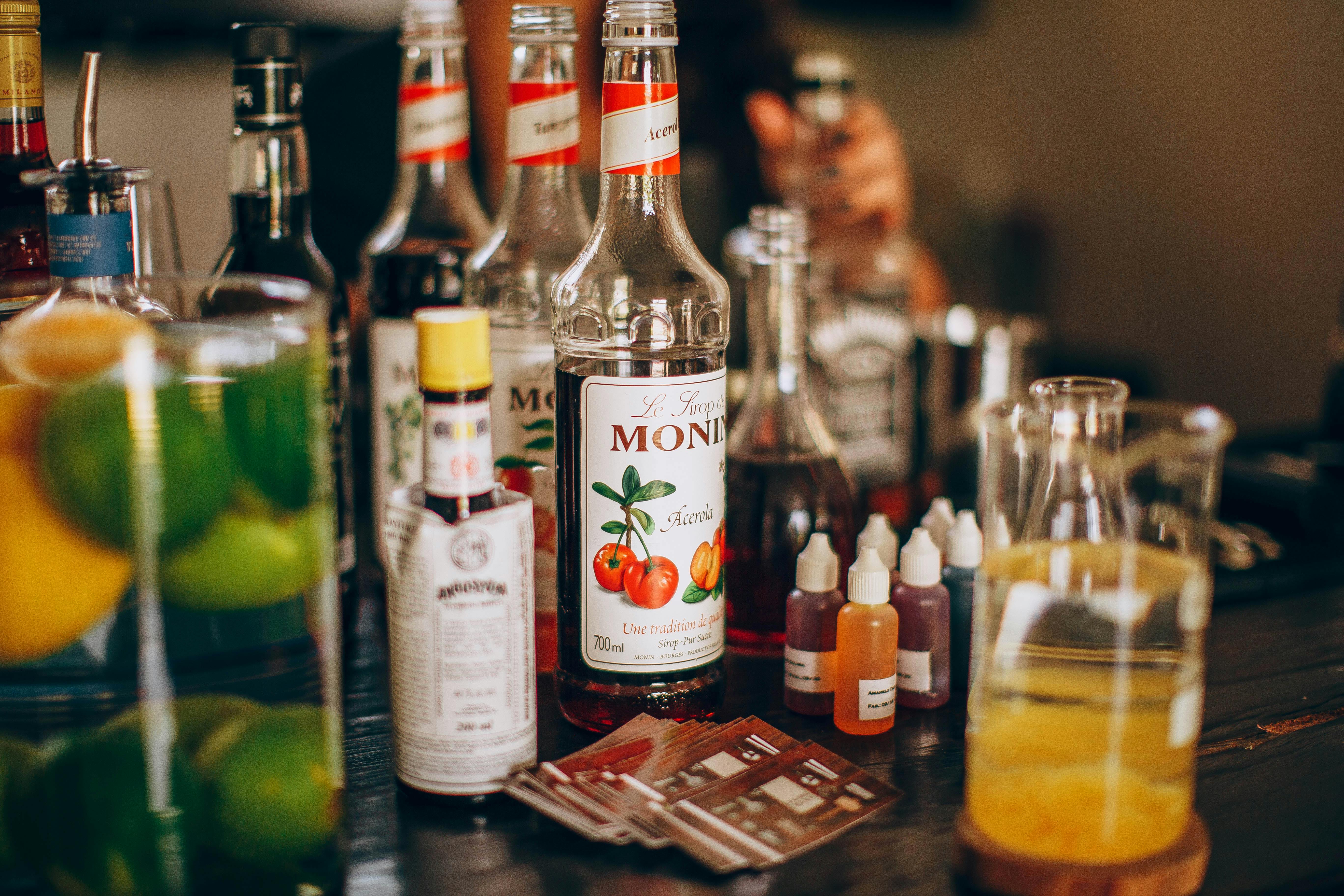 Assortment of syrups and alcohol on bar counter · Free Stock Photo