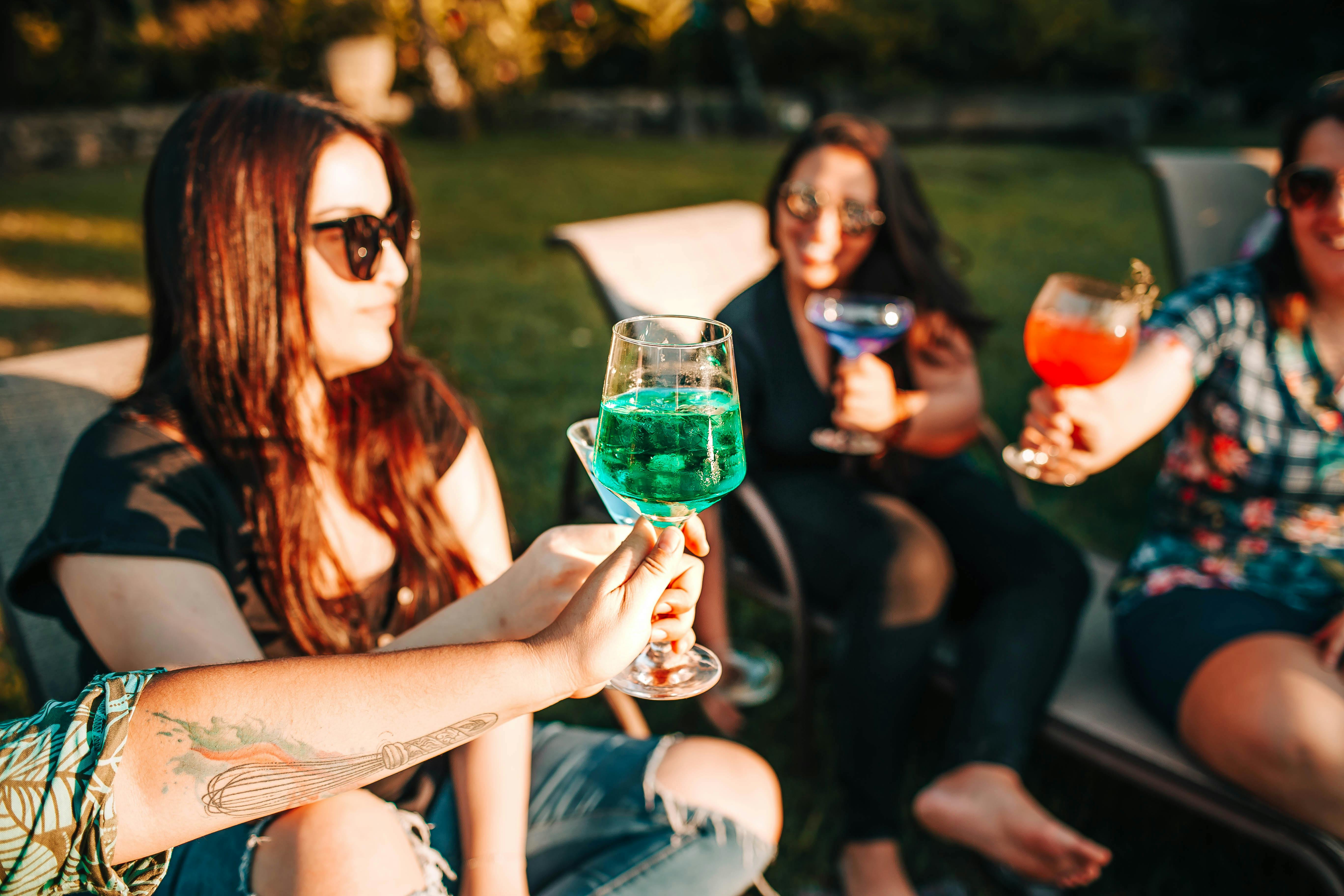 Cheerful women with cocktails resting on loungers in sunlight · Free ...