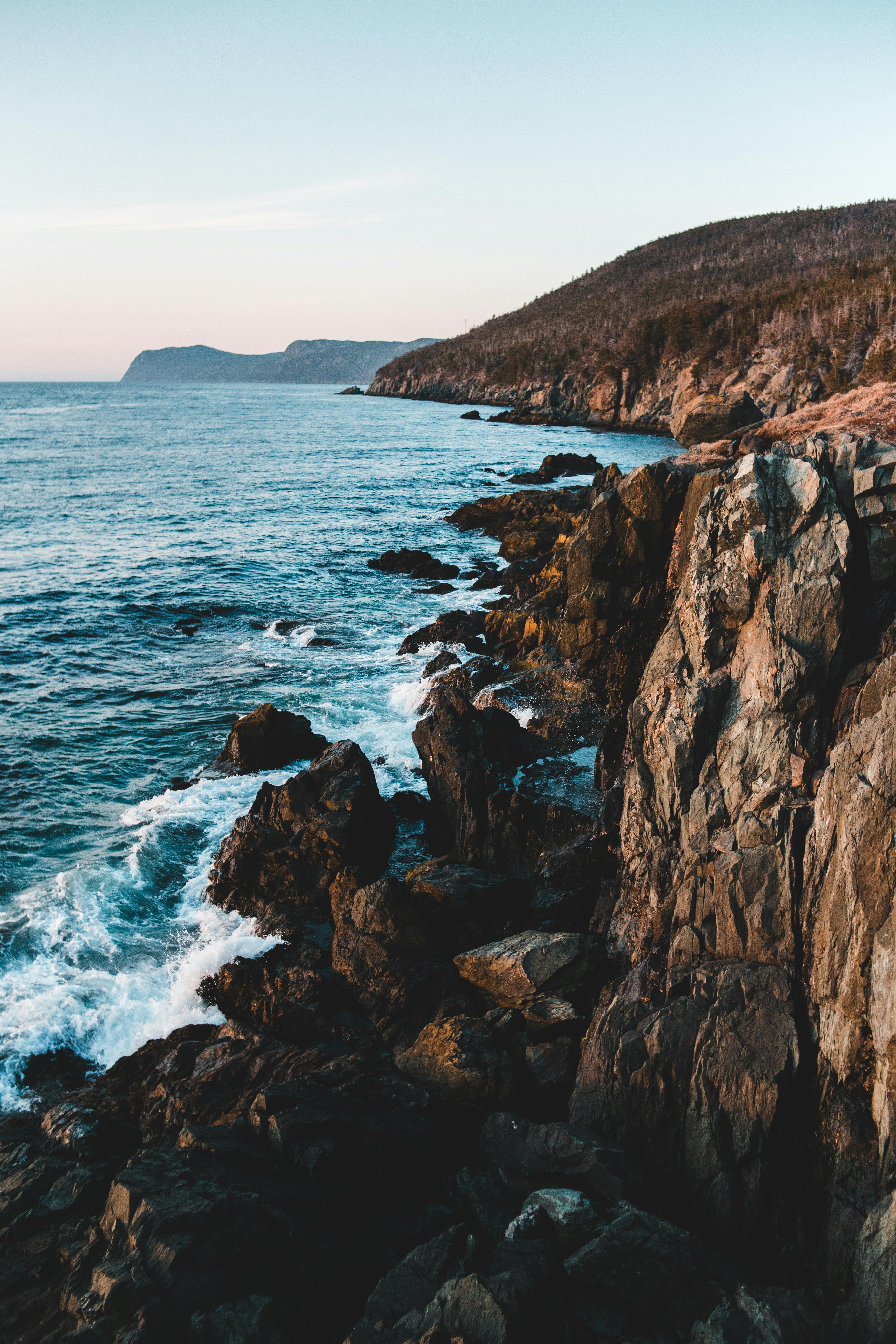 Unrecognizable tourist standing under rough cliff in mountains during ...