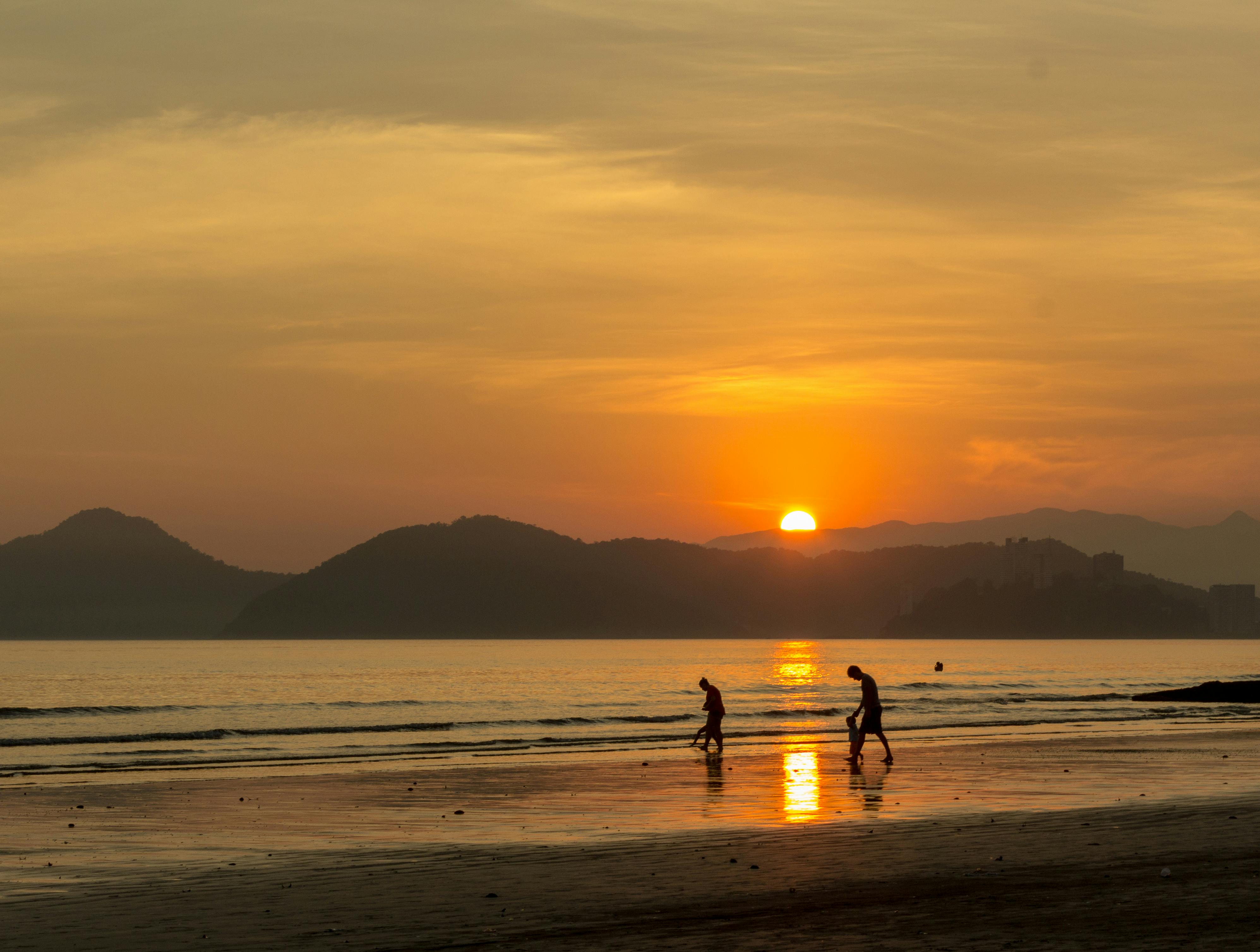 Unrecognizable tourists walking on sea beach at bright sunset · Free ...
