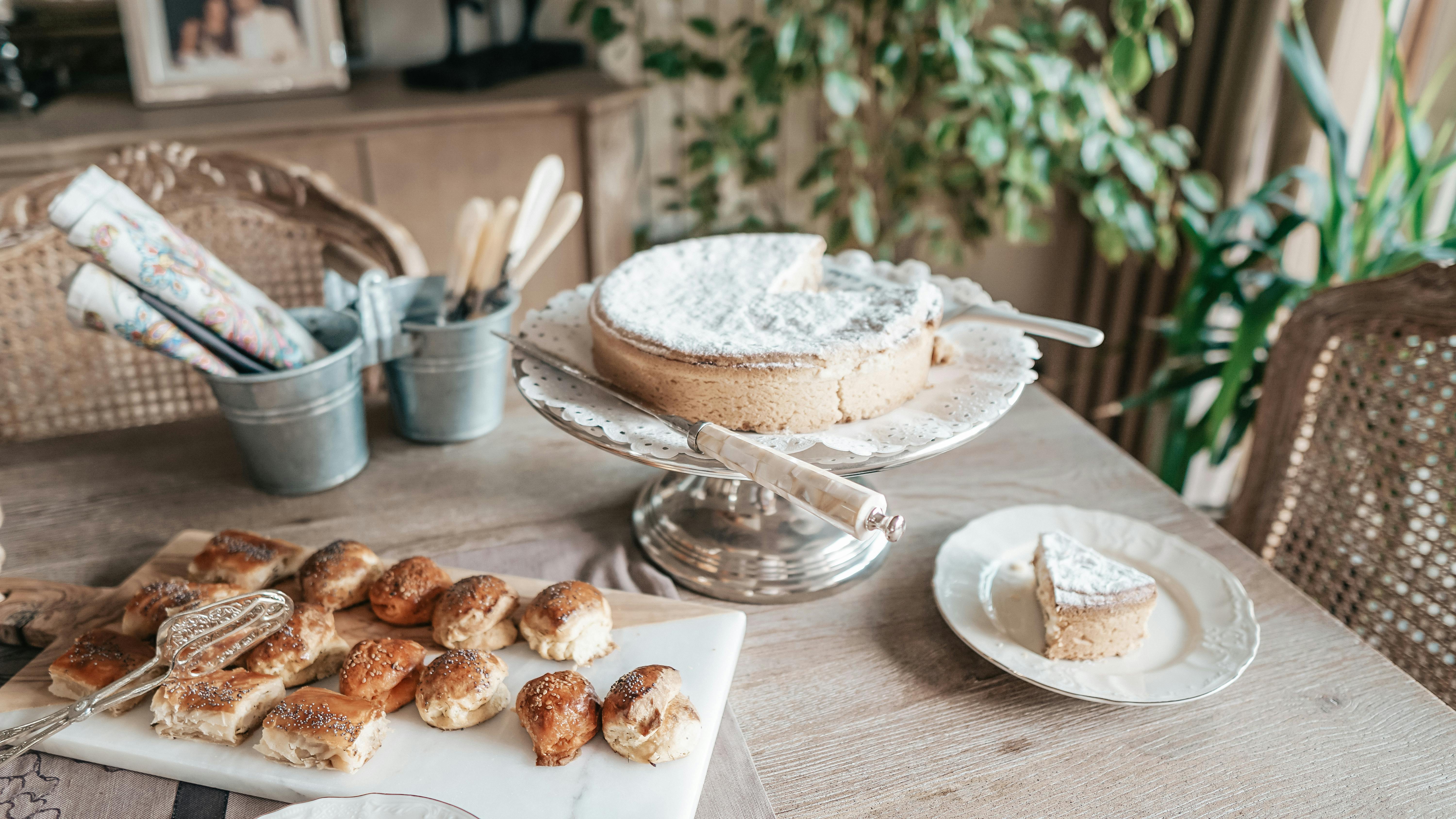 Delicious cake and buns on table in flat · Free Stock Photo