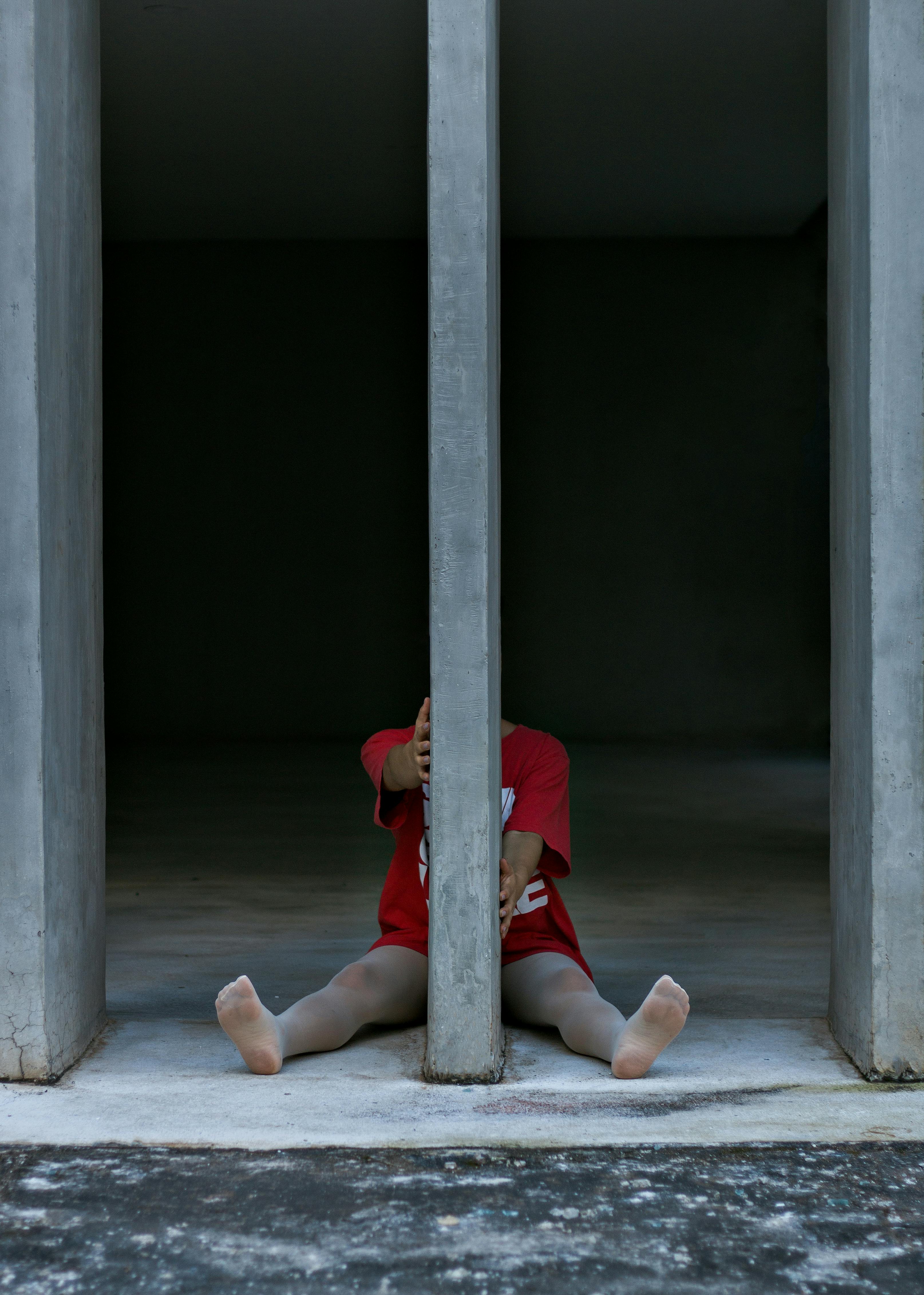 Boy Sitting Behind Column · Free Stock Photo