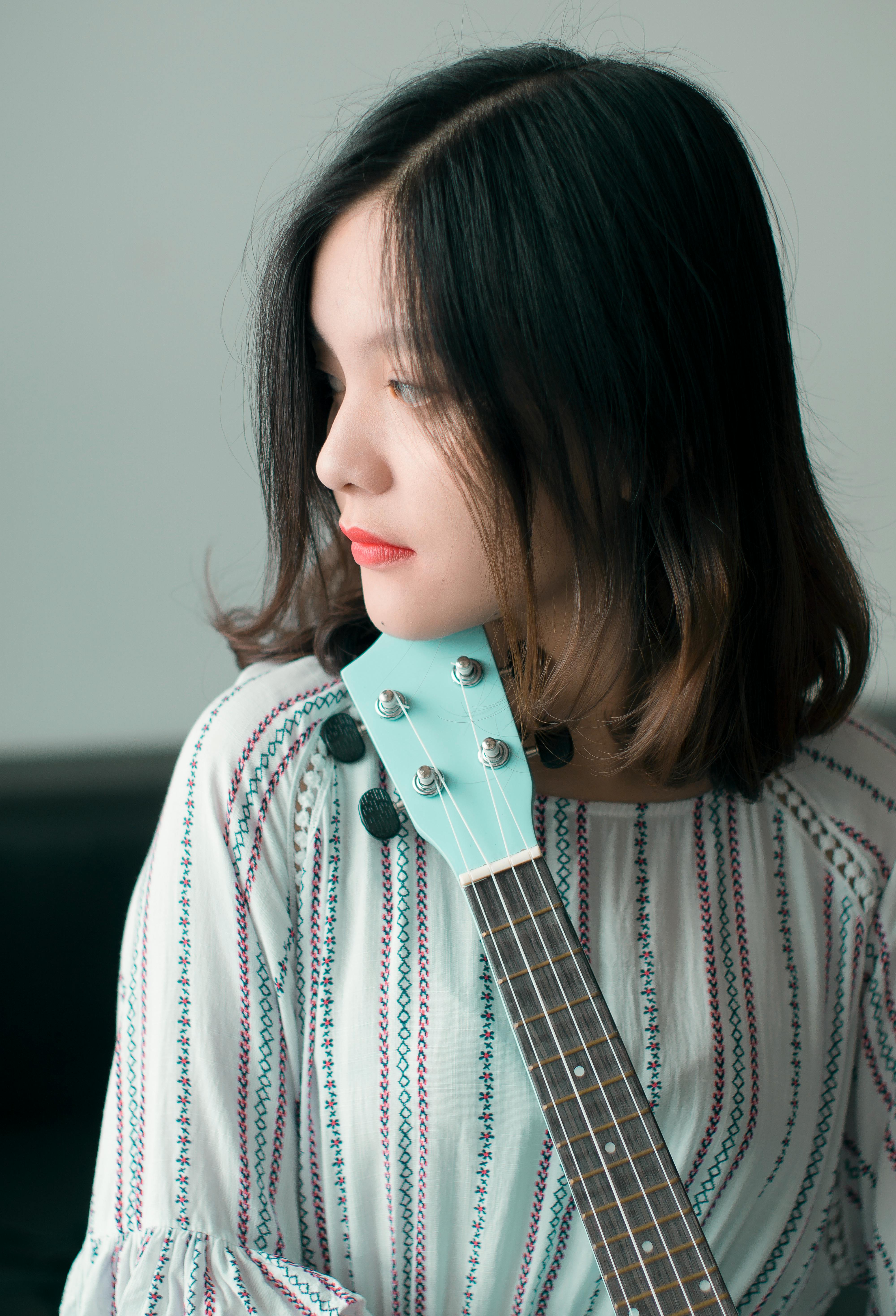 Dreamy young ethnic female musician with electric guitar · Free Stock Photo