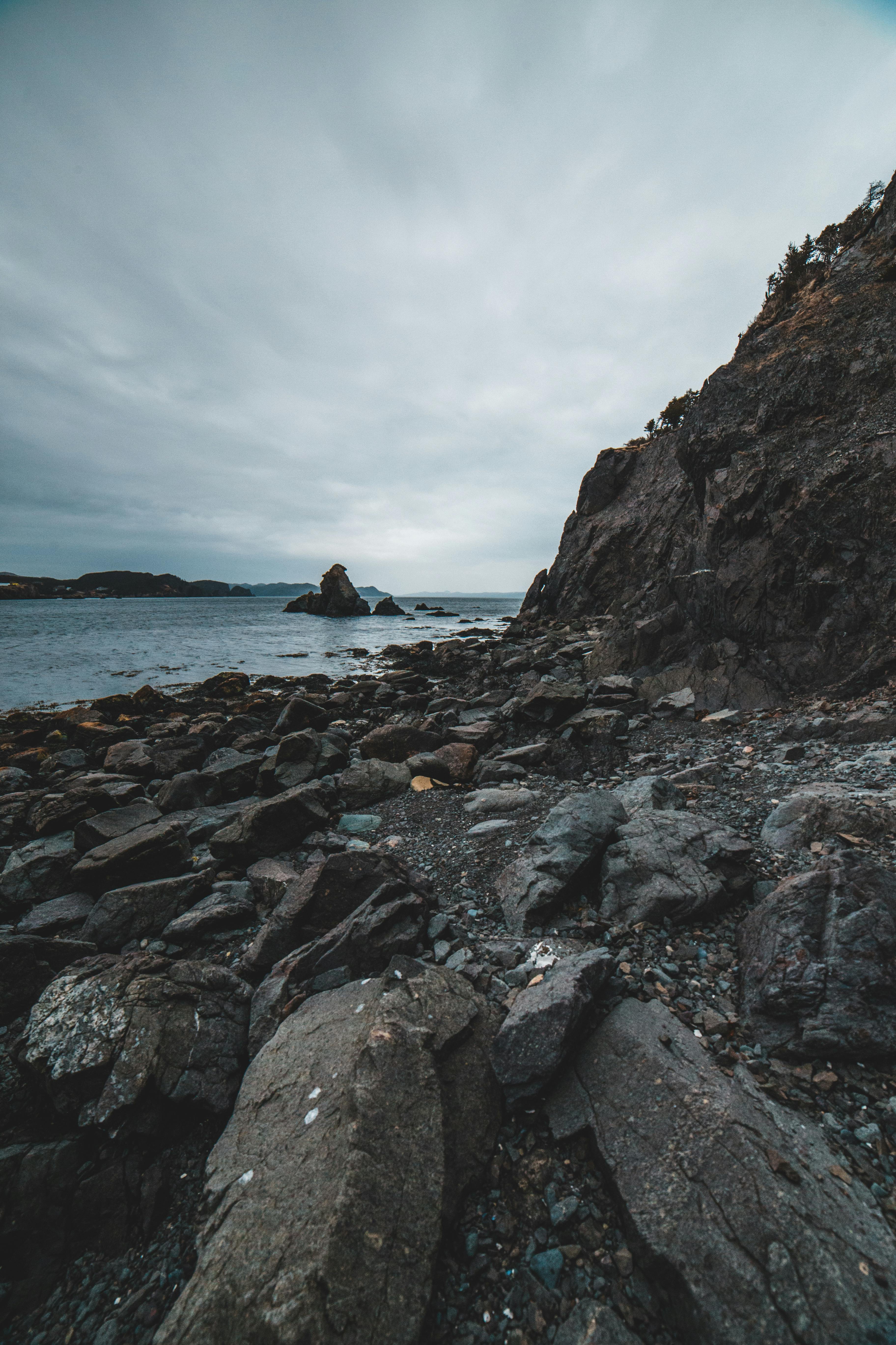 Huge cliff and rocky seashore · Free Stock Photo