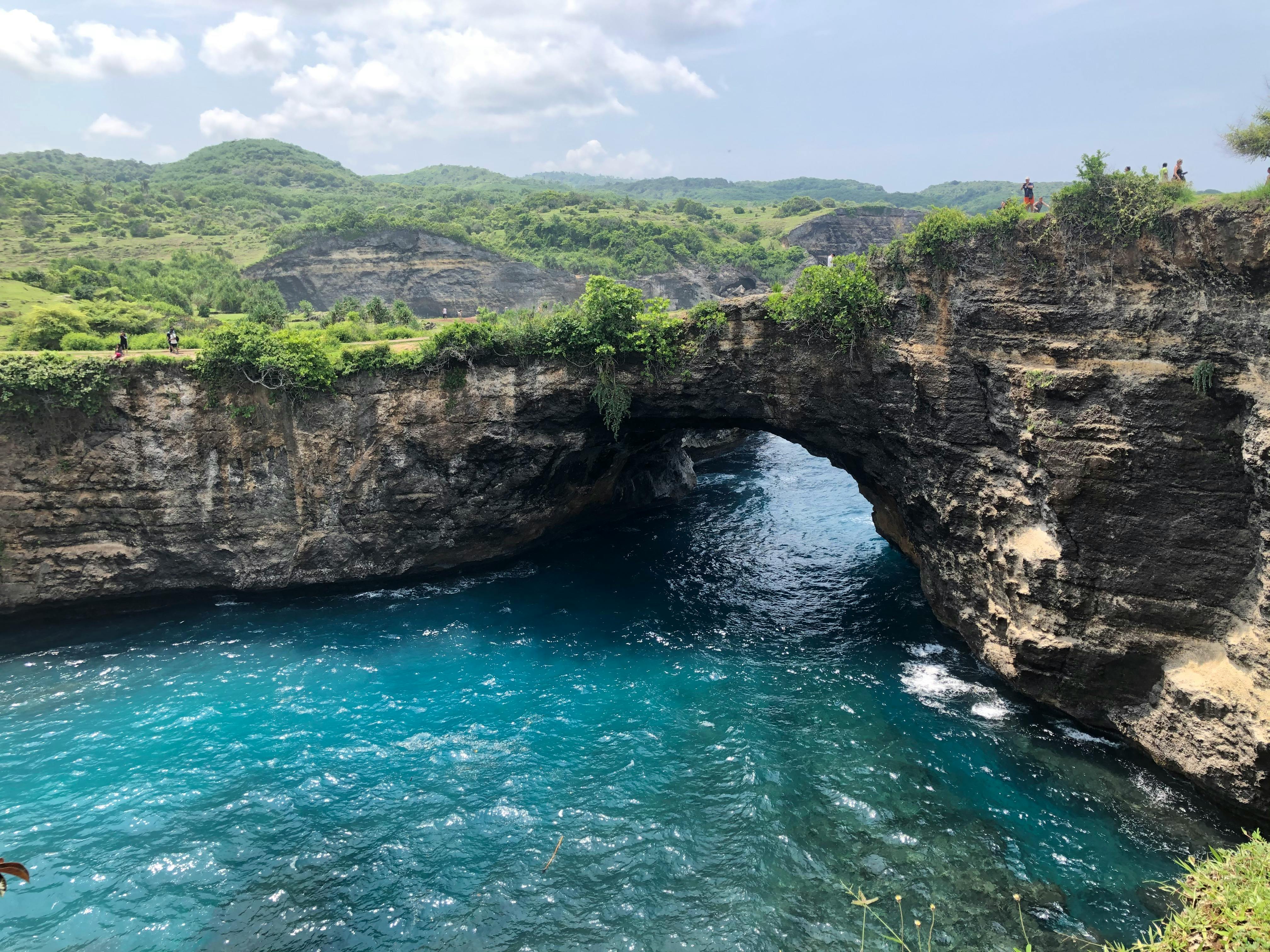Rough cliff in rocky terrain with river · Free Stock Photo